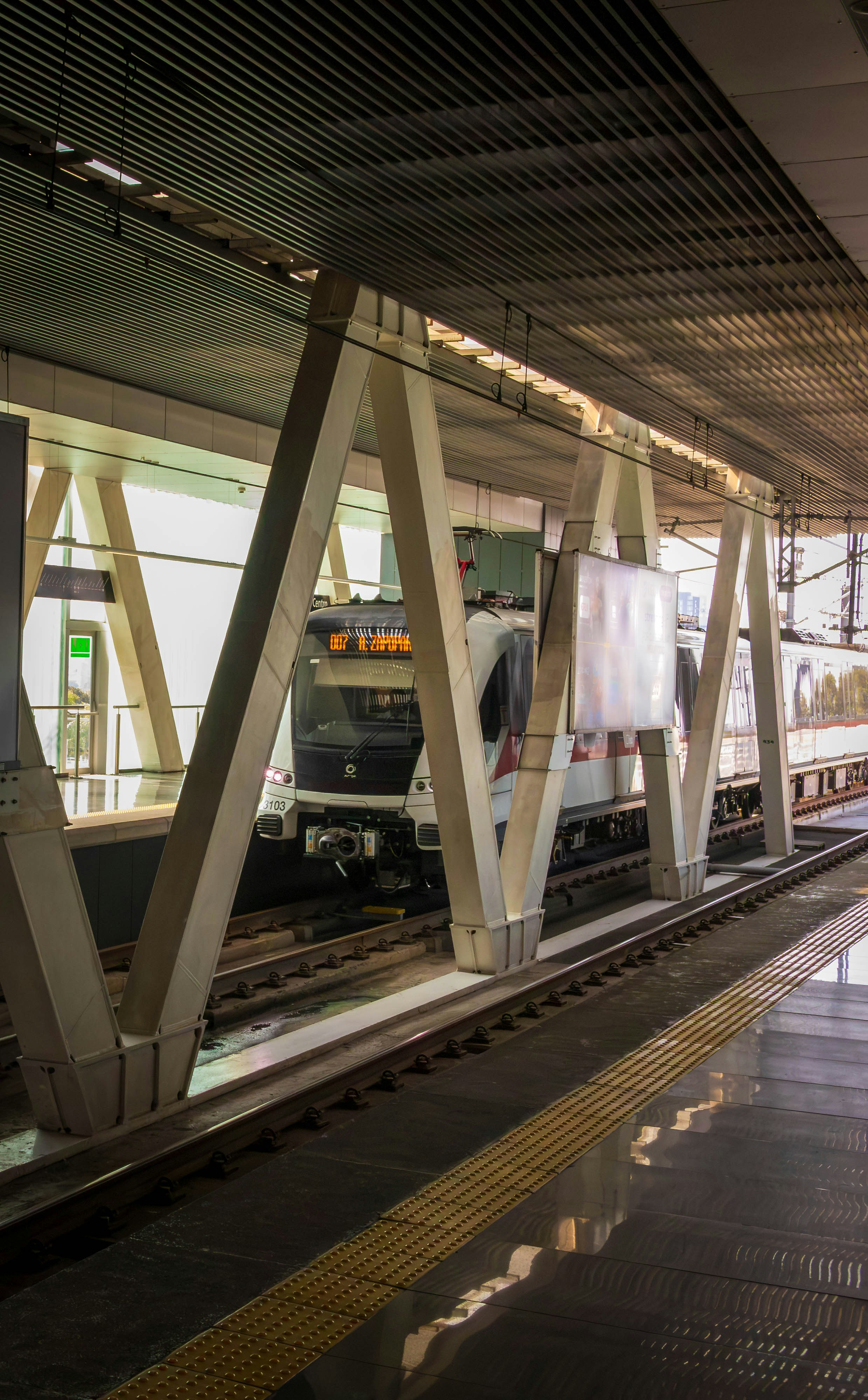 Platform Arrival: A Sleek Train Pauses Between Steel Pillars
