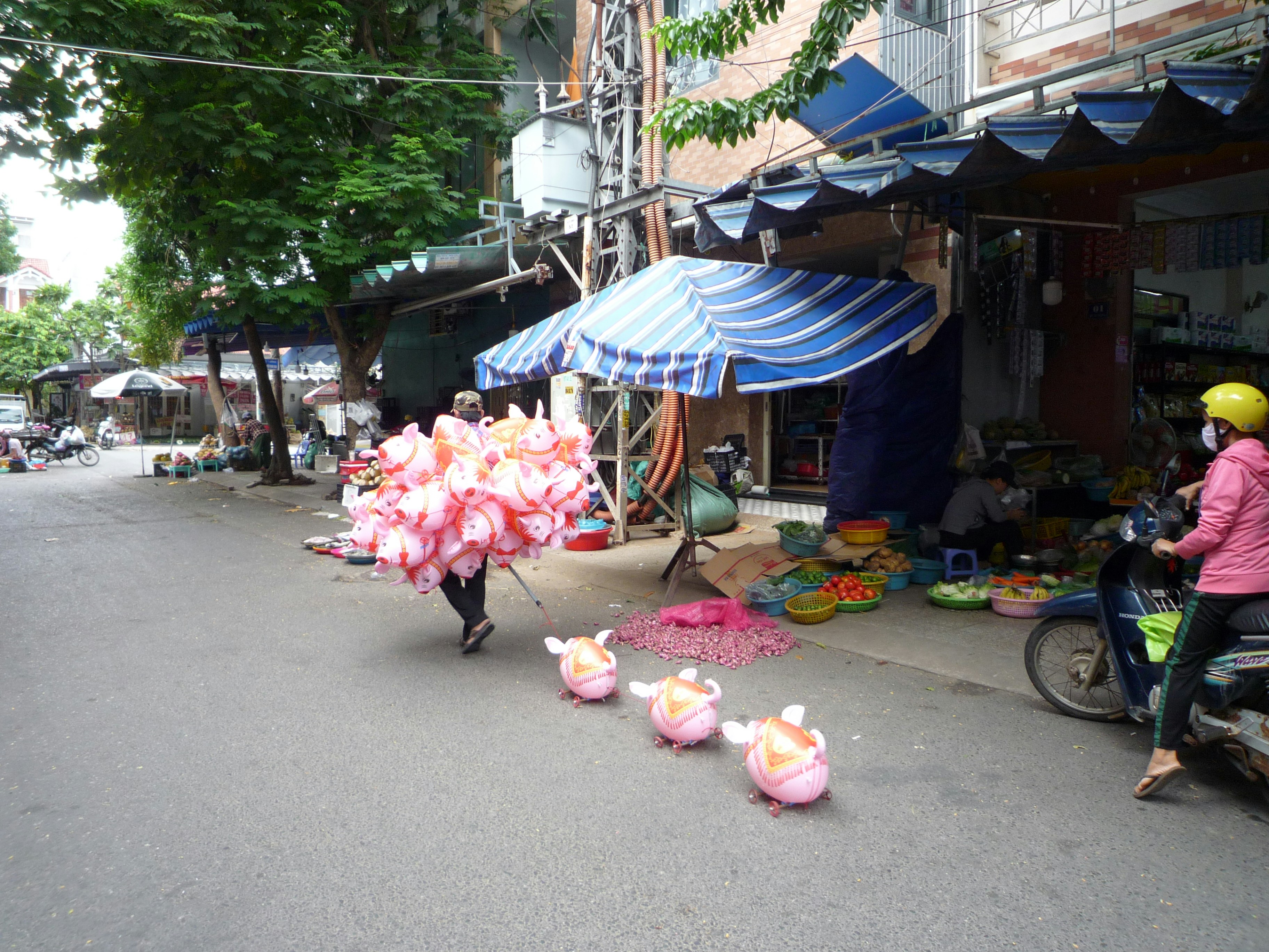 Street Vendor Carousel: Pink Cotton Candy Orbs on a Bustling Roadside