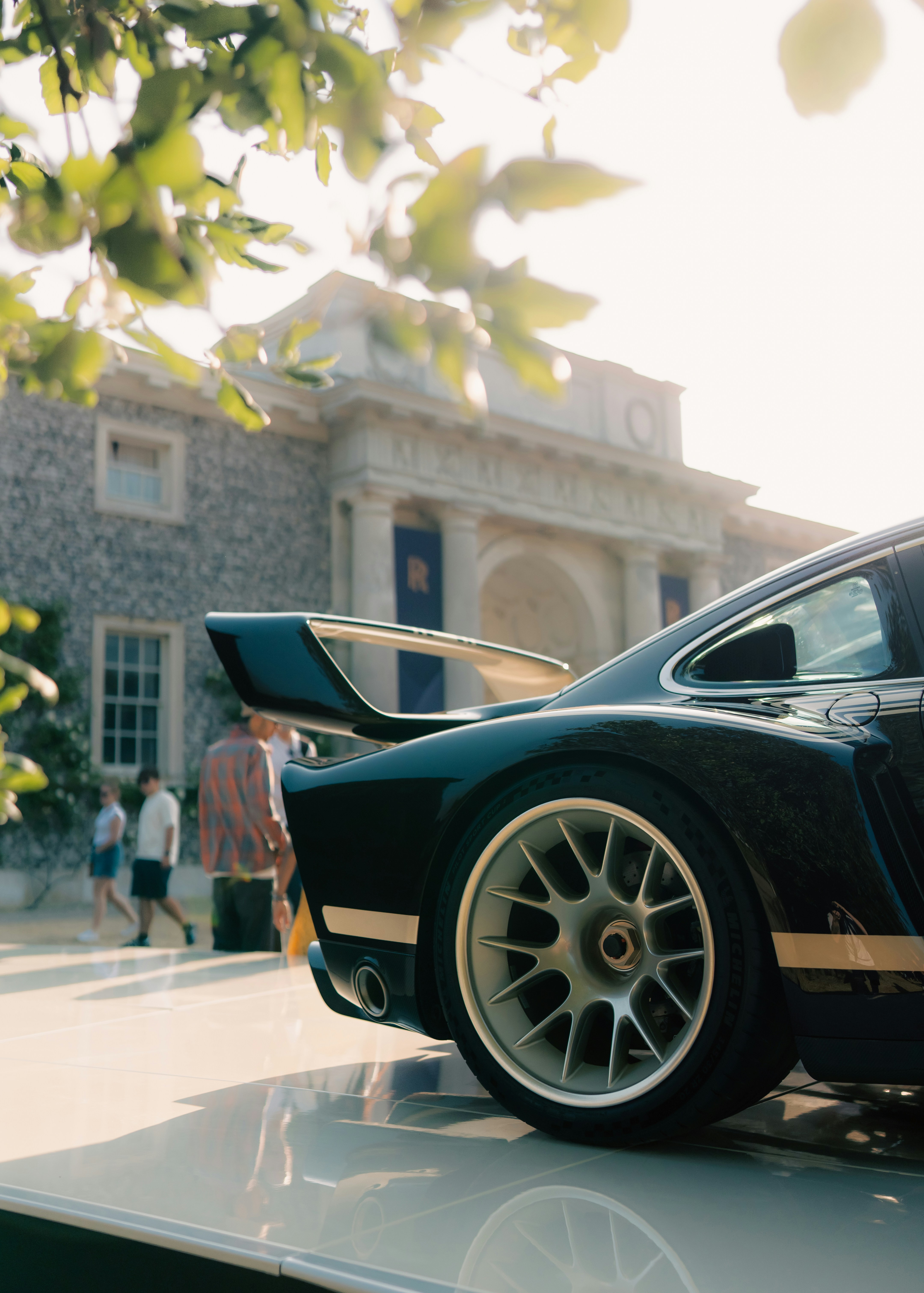 Rear Wing and Wheel Details of a Sports Car in Urban Gallery Setting