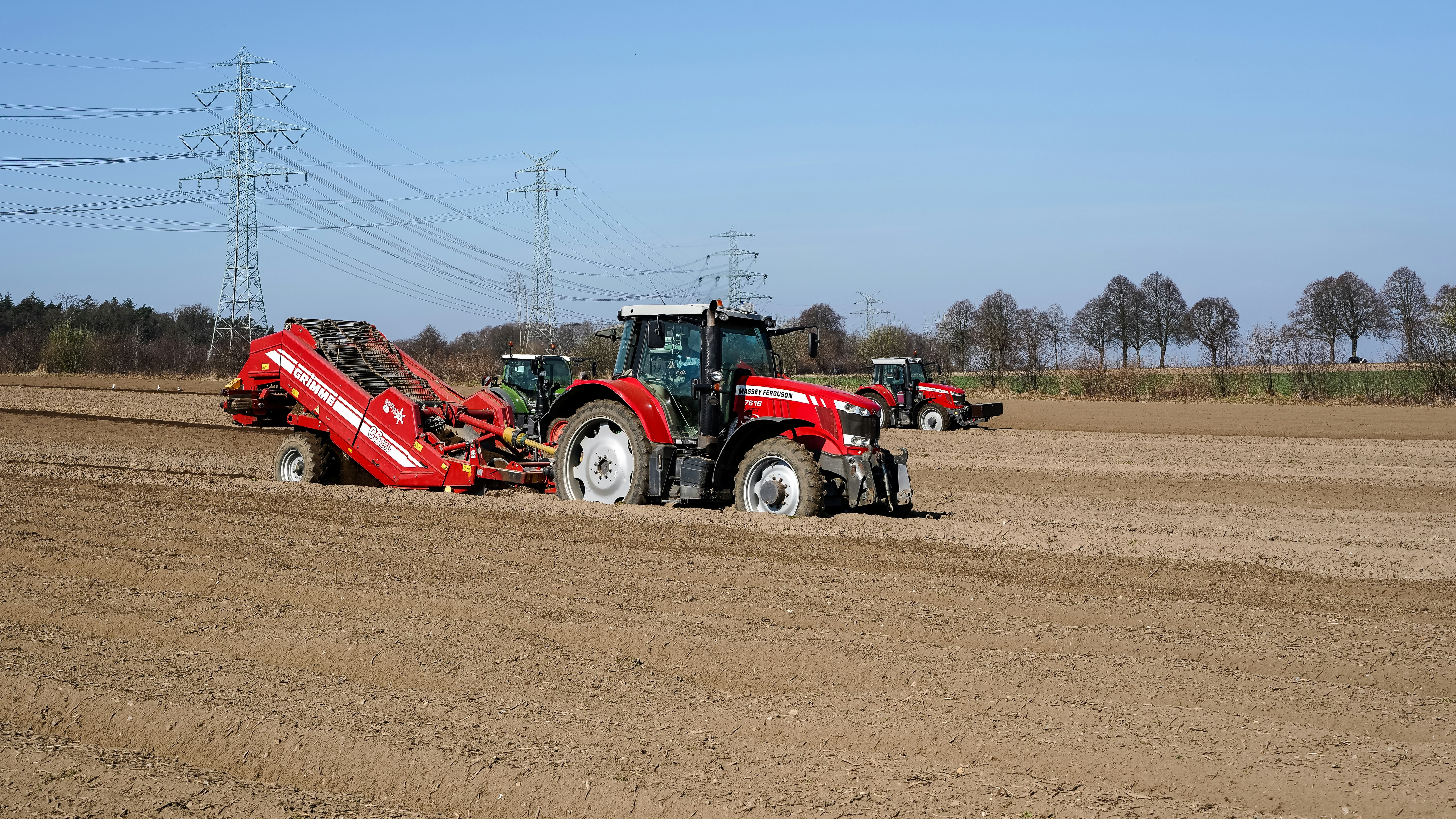 Red Tractors at Work: Field Preparation Under Clear Sky