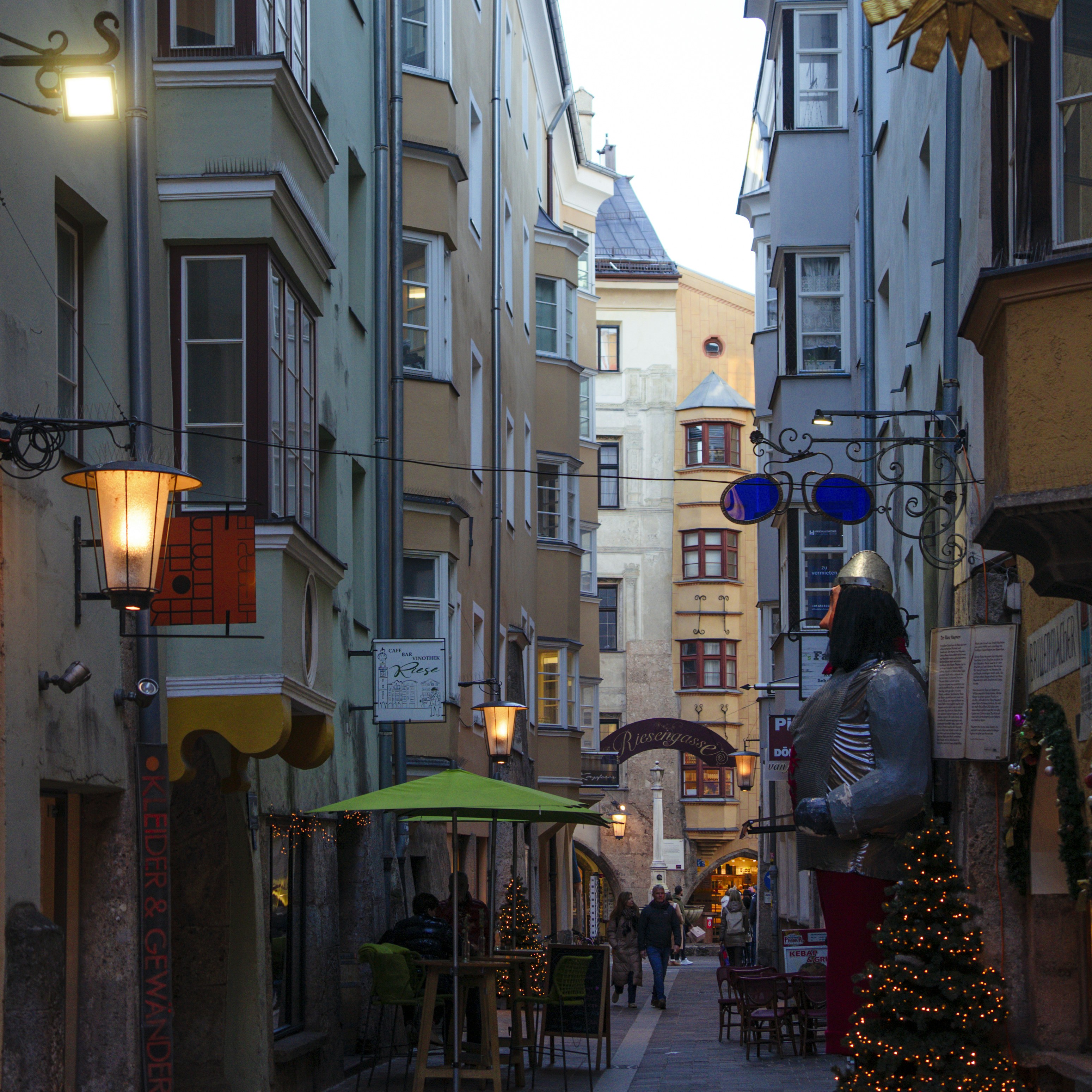Cobbled Alley Awakens: Warm Lights and Quiet Activity in a Narrow European Street