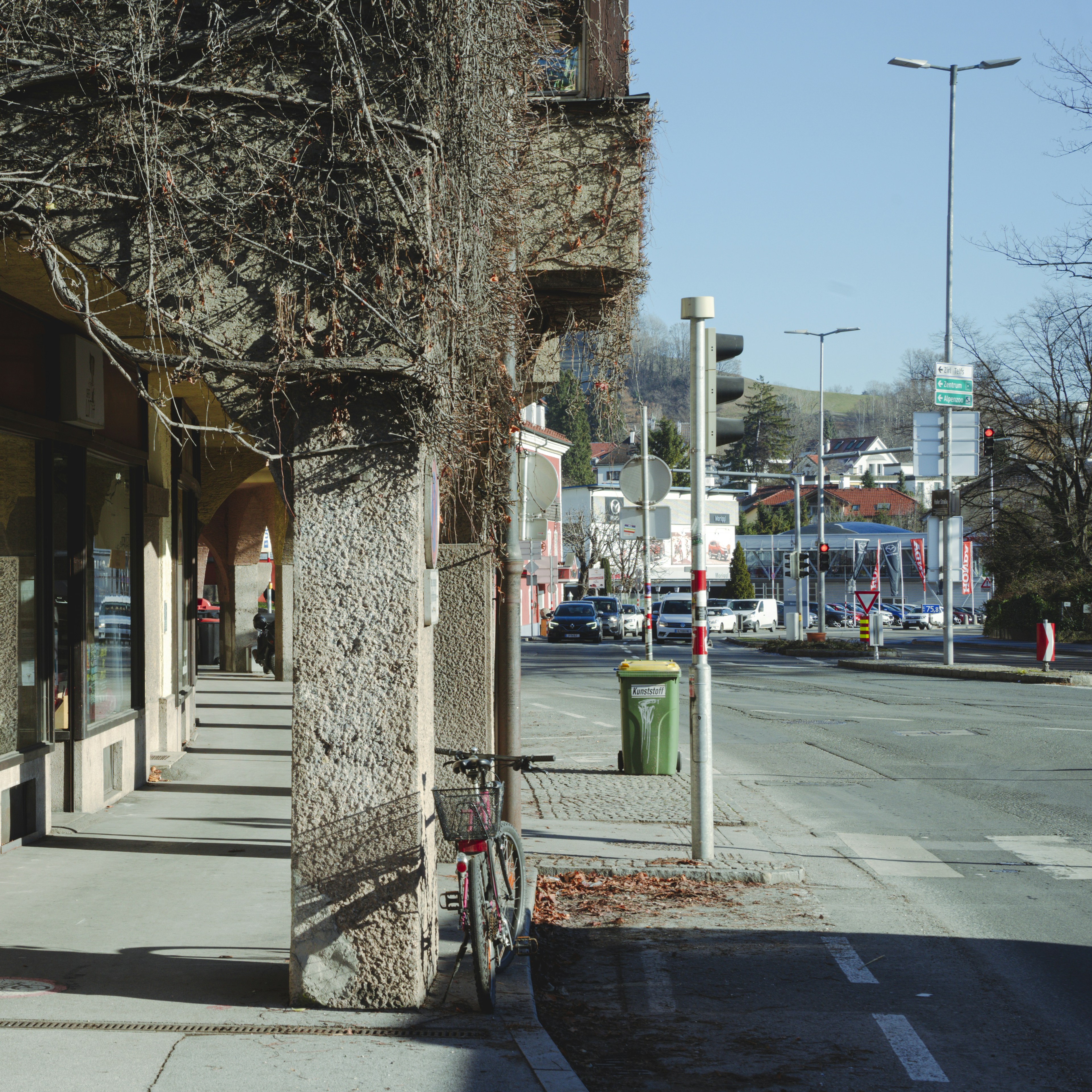 Urban Sidewalk Echoes: A Quiet Street Under the Shadow of a Cornered Tree