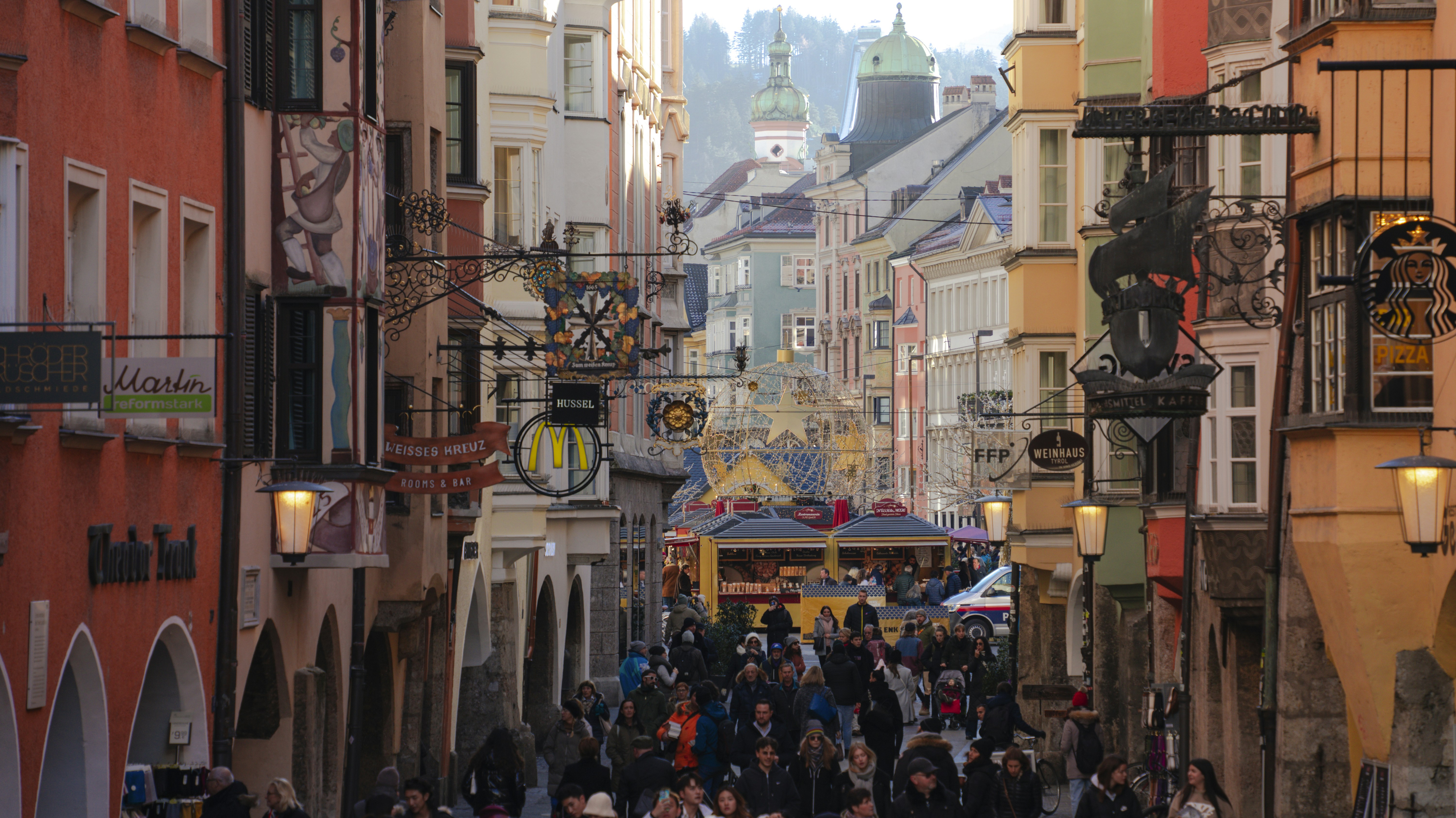 Sunlit Old Town Promenade Amid Festive Street Decor