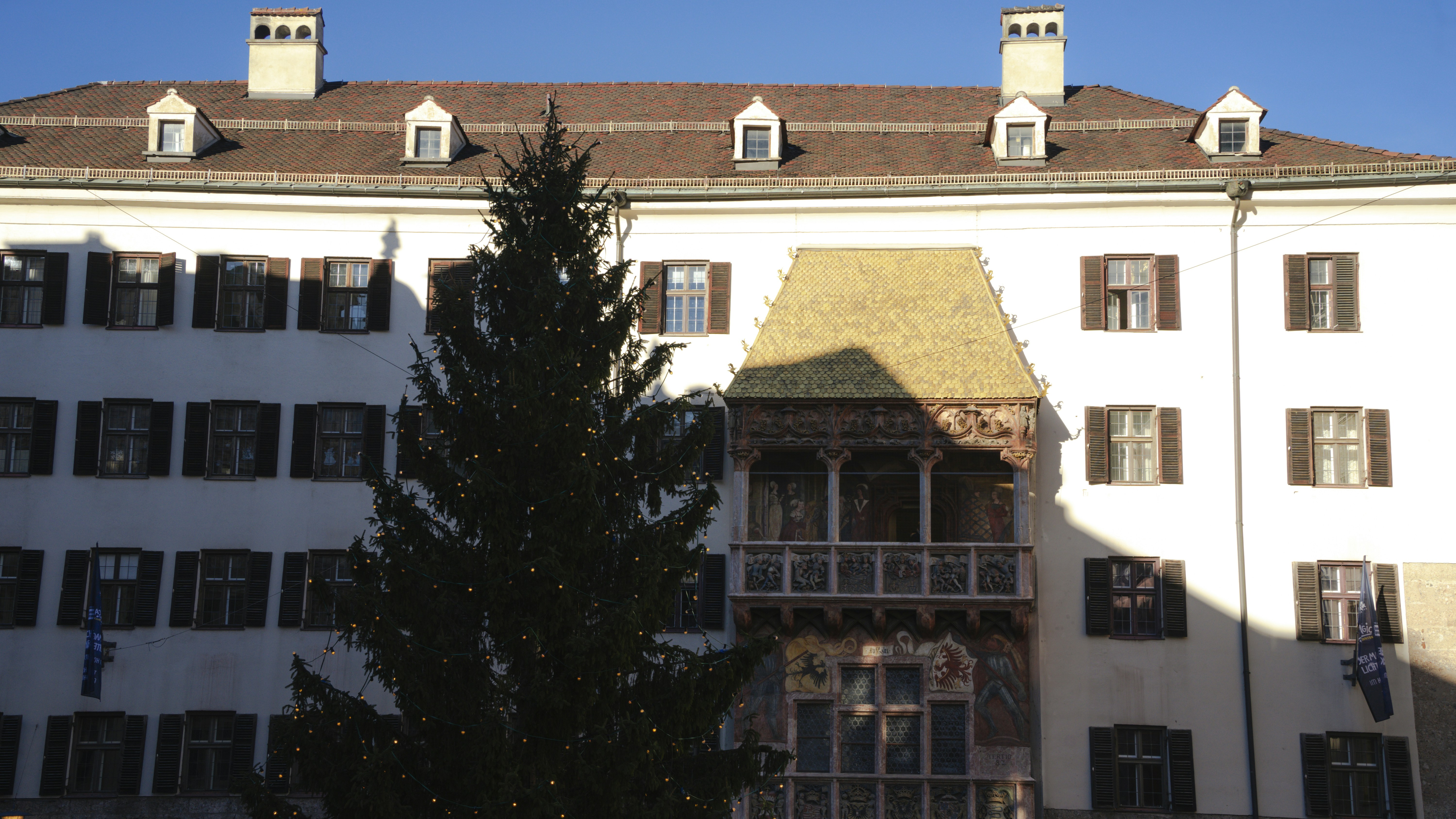 Sunlit Facade with Central Balcony and Tree Shadow