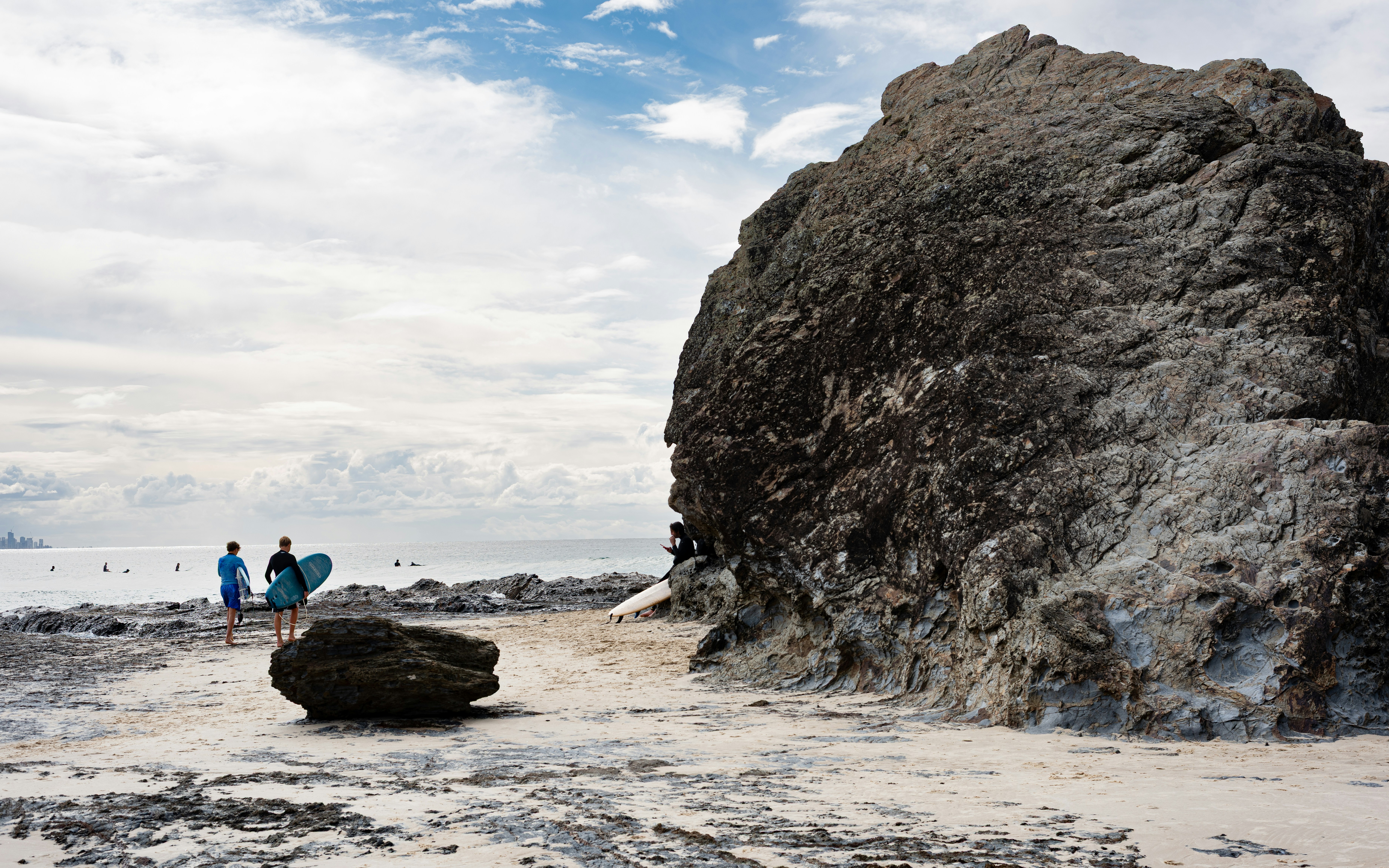 Surfing silhouettes at the edge of a windswept shore