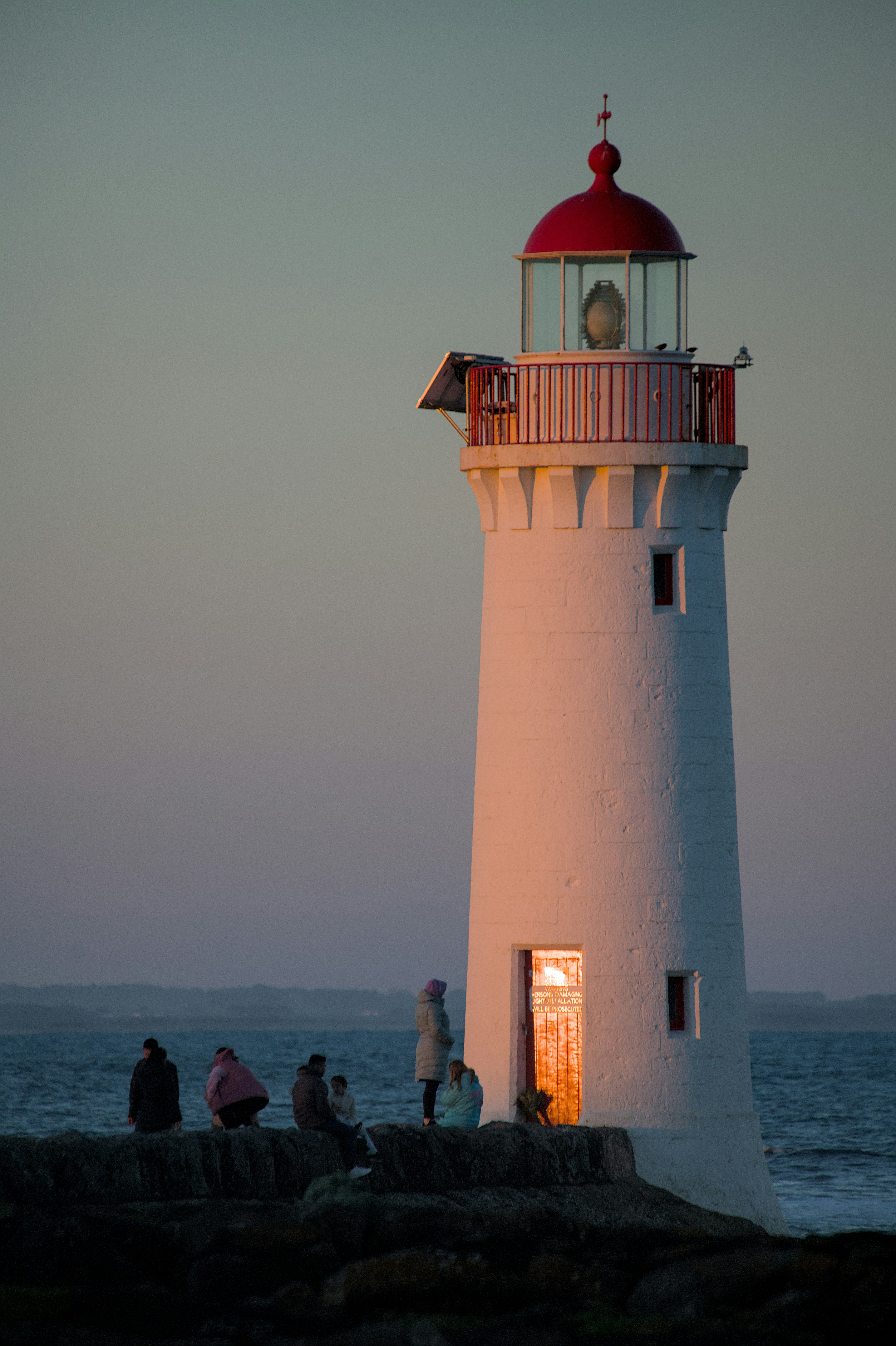 Beacon at Dusk: The Red-Capped Lantern Standing Over Quiet Waters