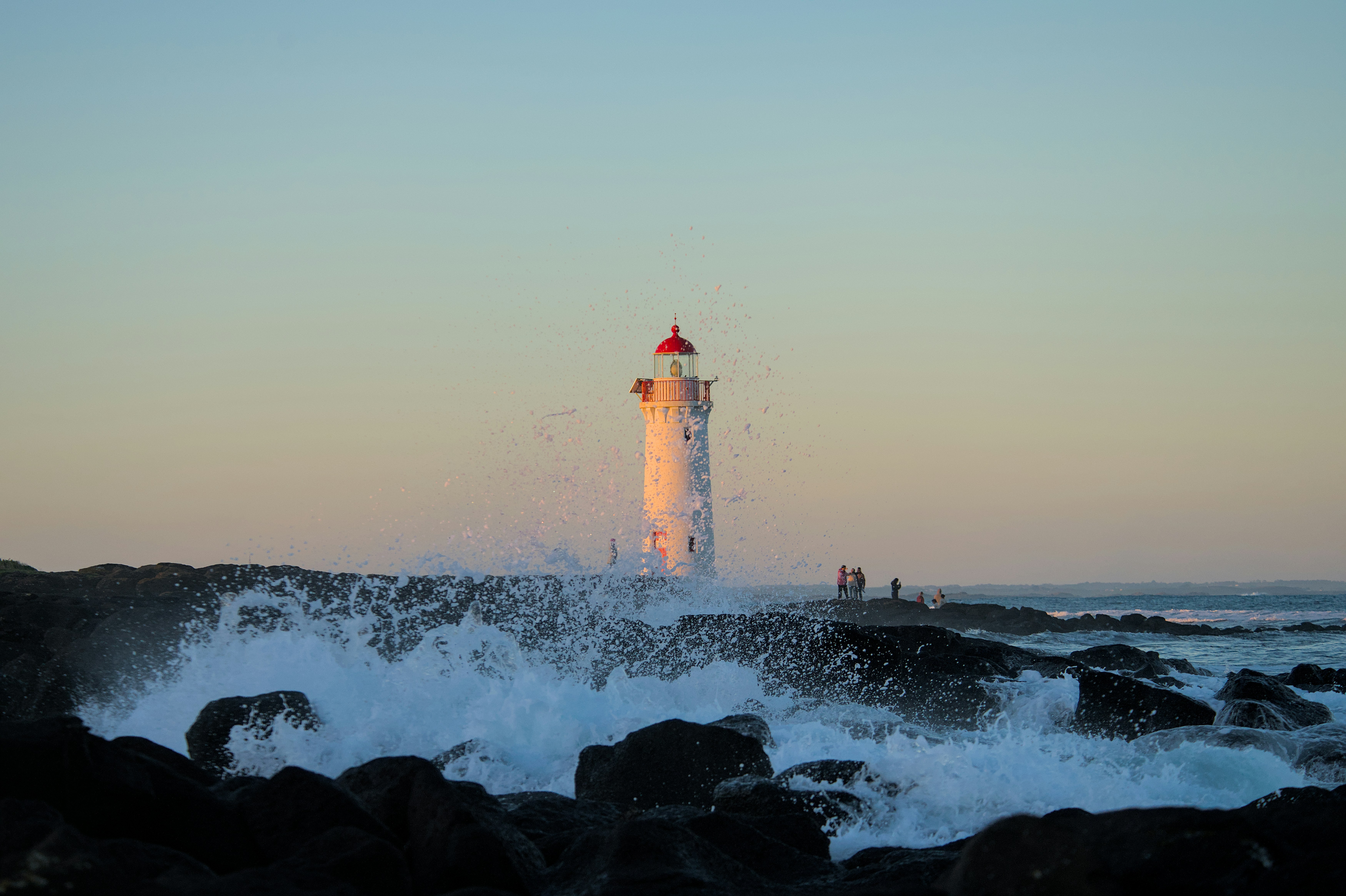 Lighthouse Sentinel: Dawn Light Over Tidal Breakers
