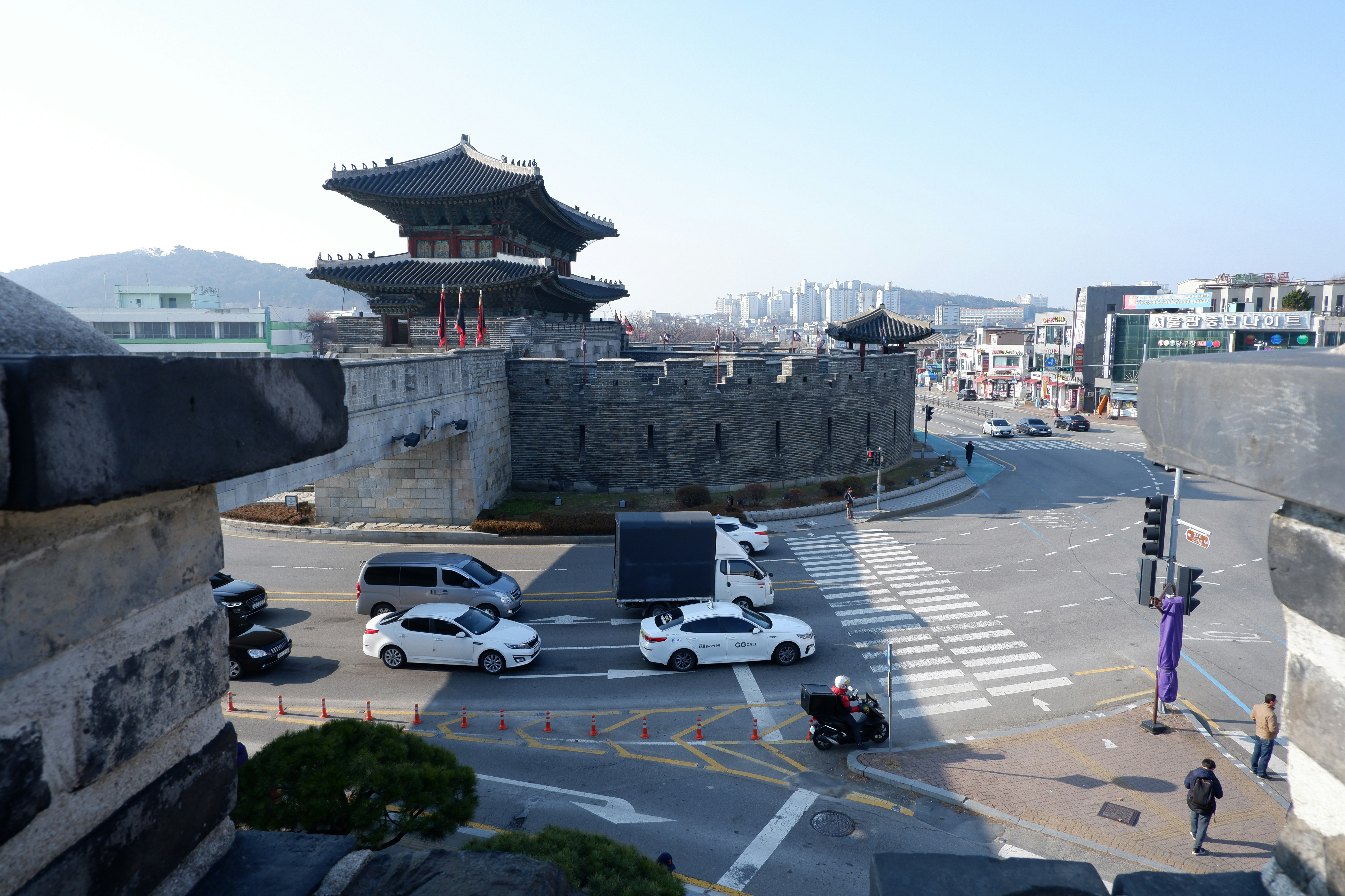 Gateway to the City: A Historic Wall Framing a Bustling Intersection