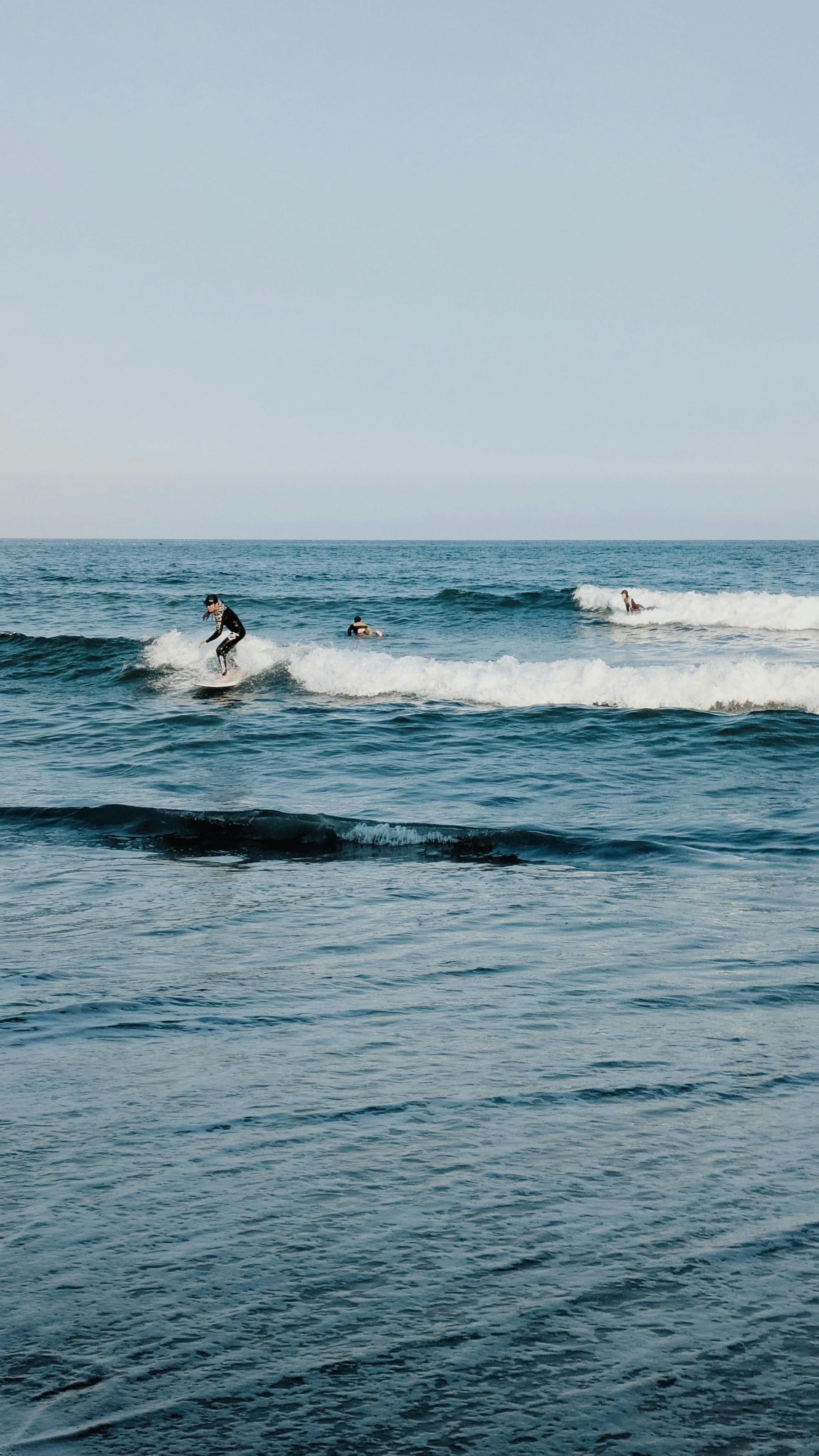 Surfing Silhouettes: A Coastal Ballet on Daylight Waves