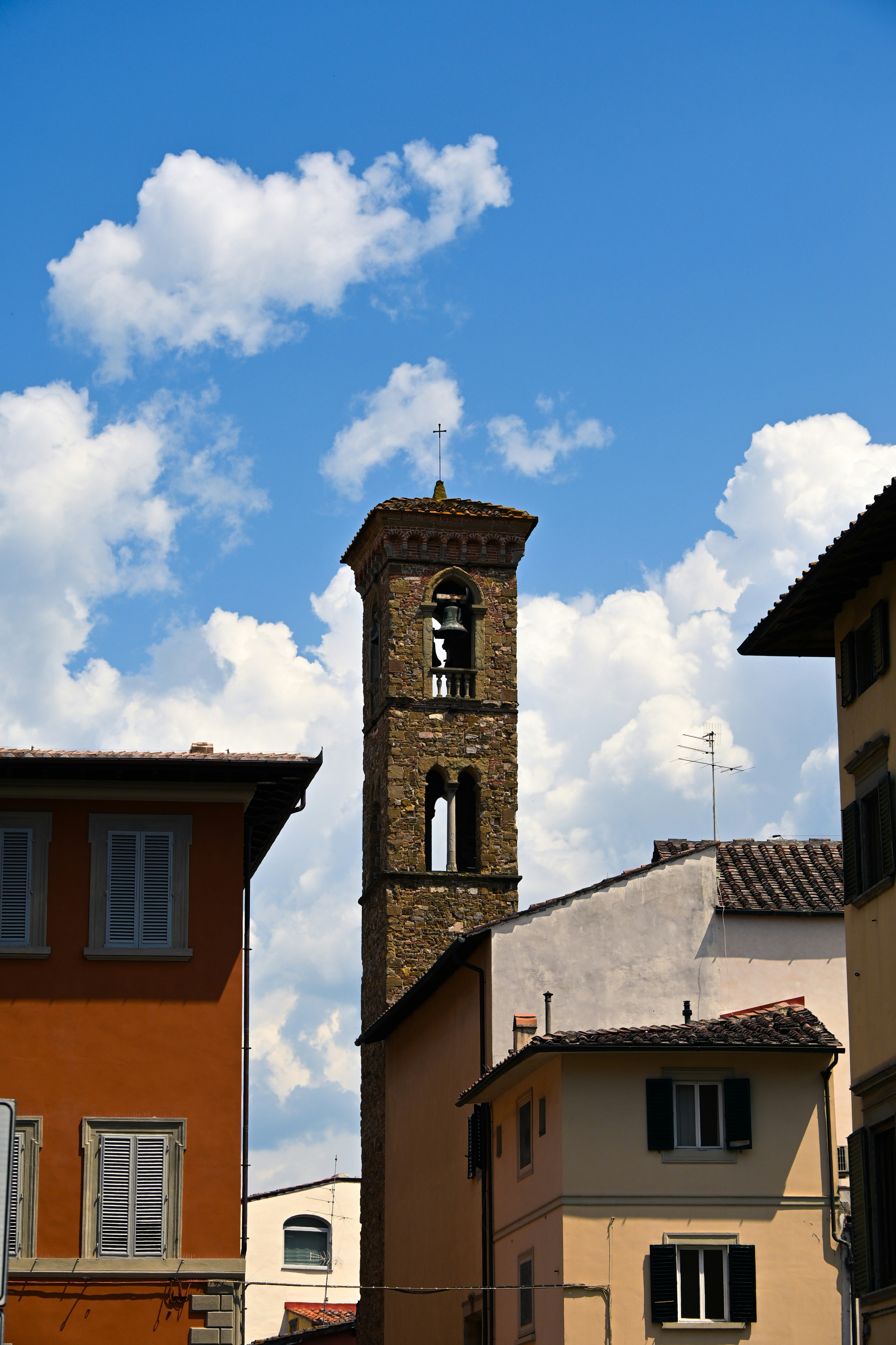 Bell Tower Rising Above a Sunlit Tuscan Street