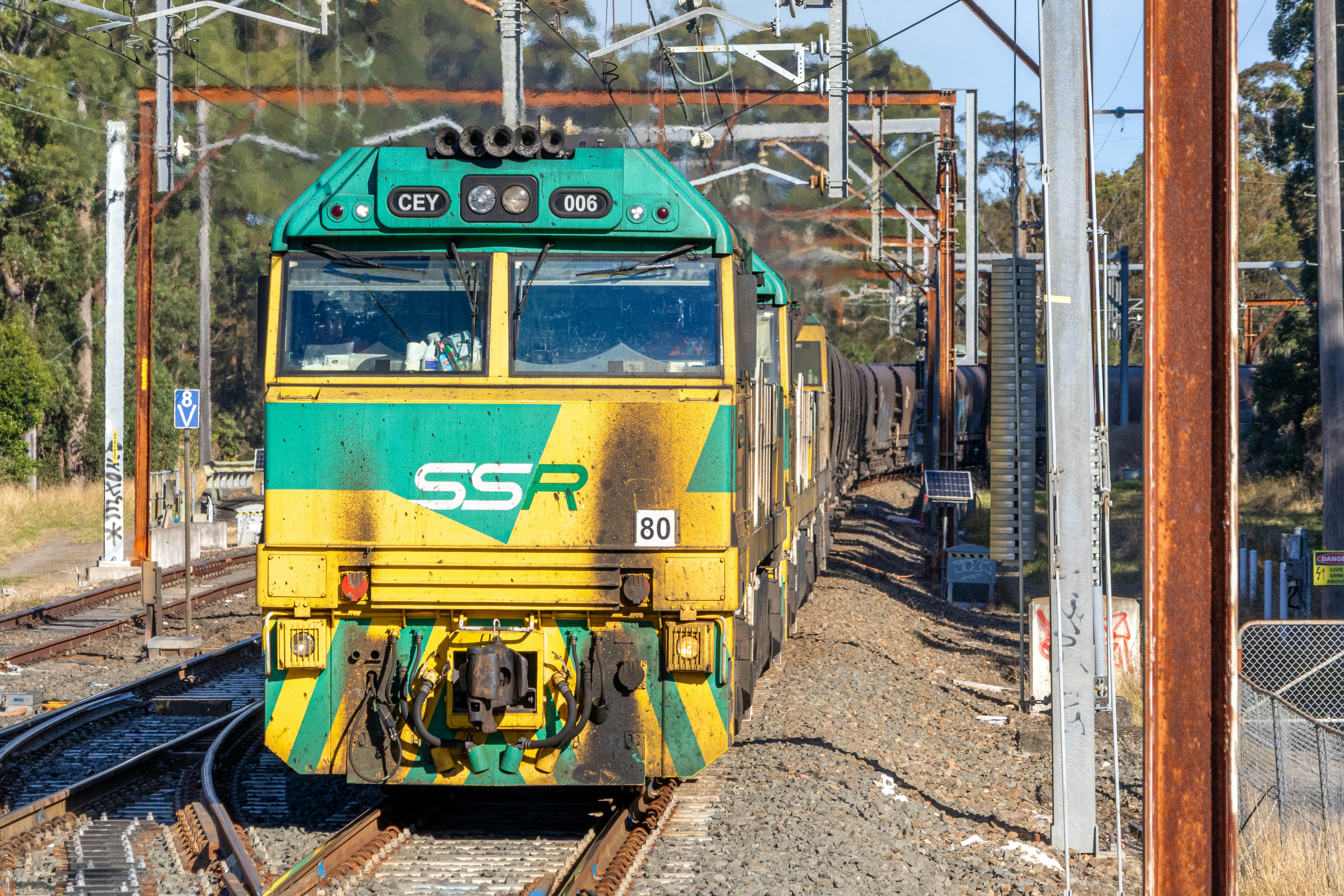 Green and Yellow Locomotive Reigns Over Rusted Tracks