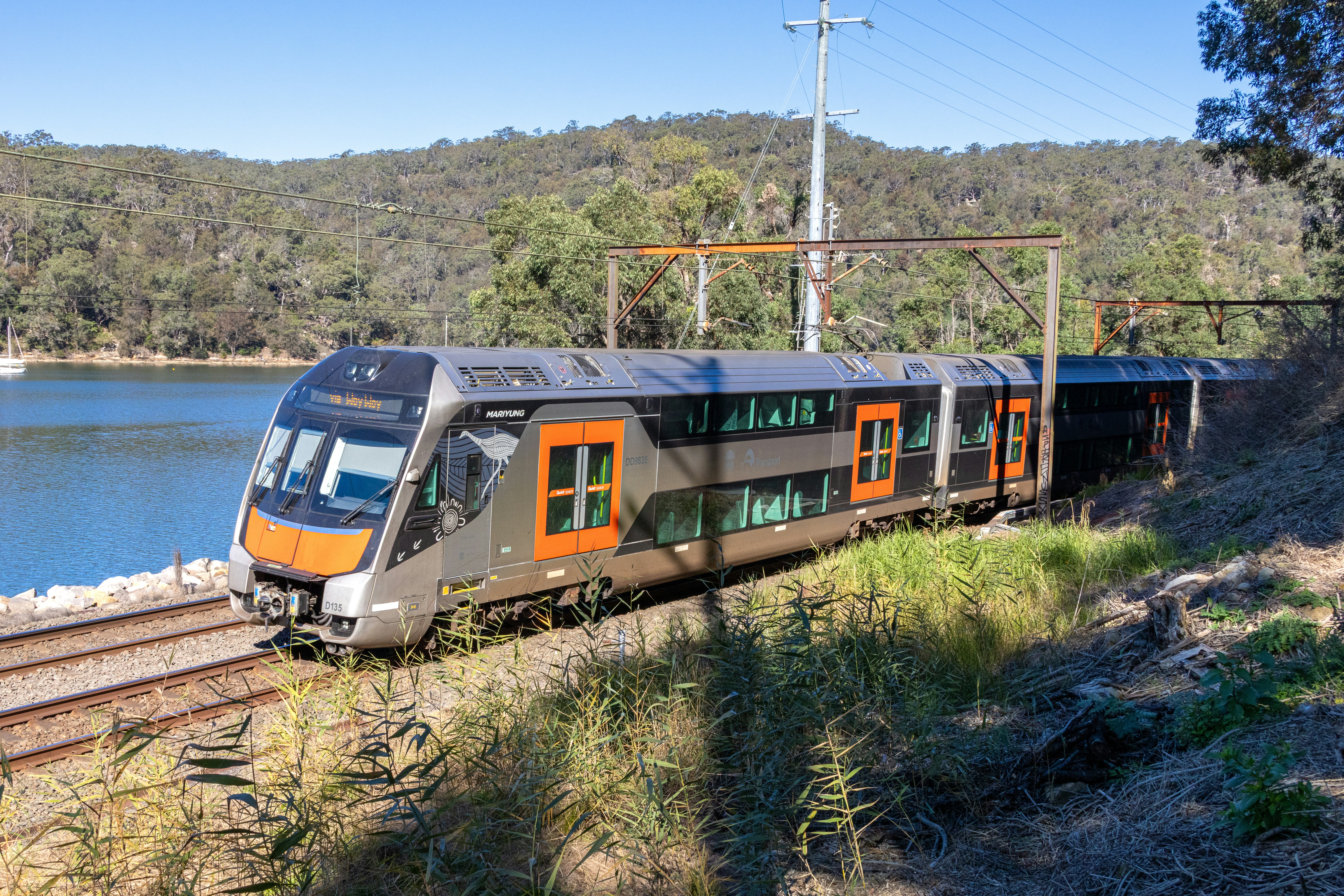 Electric Glen: A Modern Train Gliding Along a Lakebank
