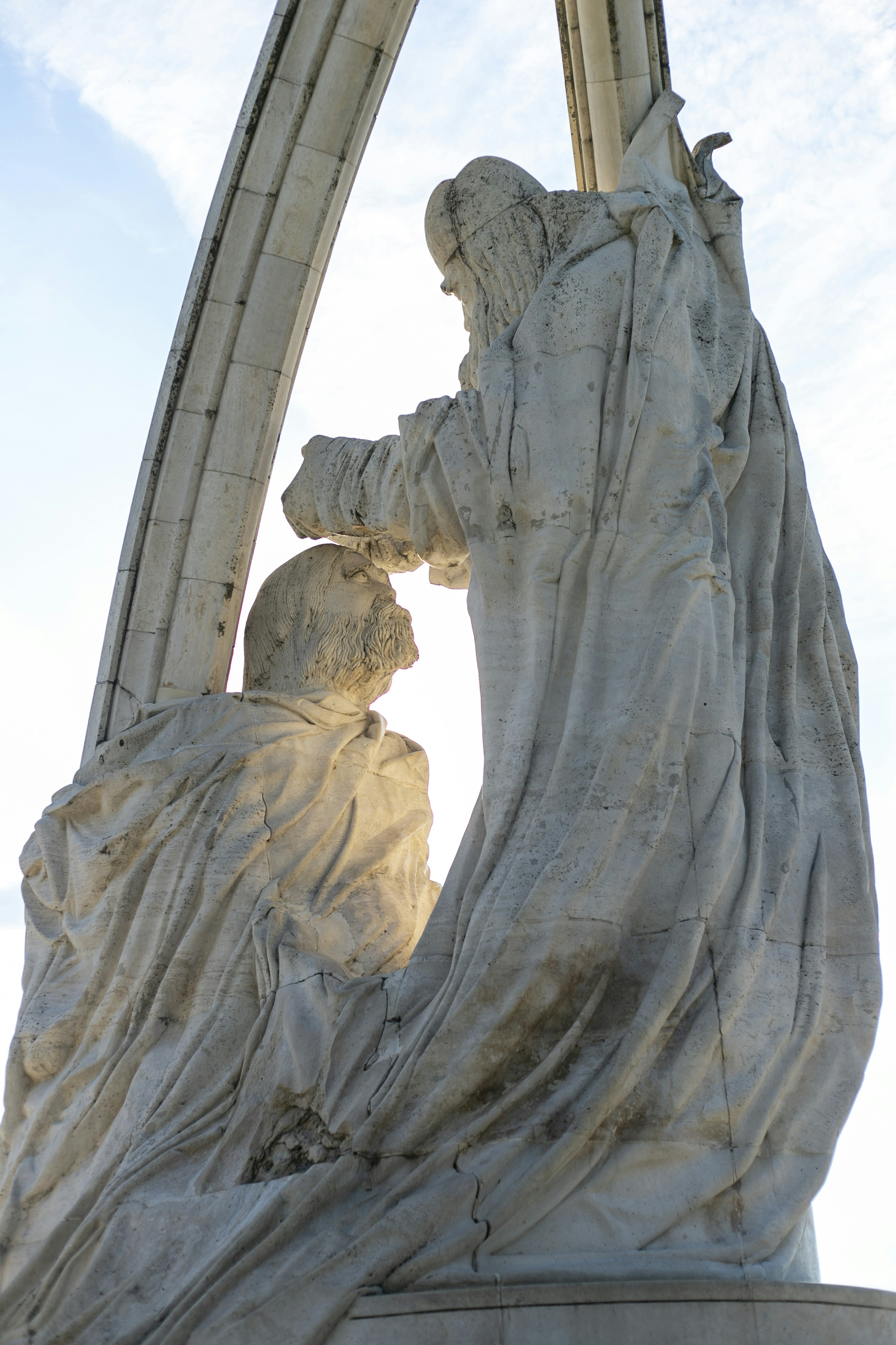 Grace in Stone: A Statue Reaching Toward the Light