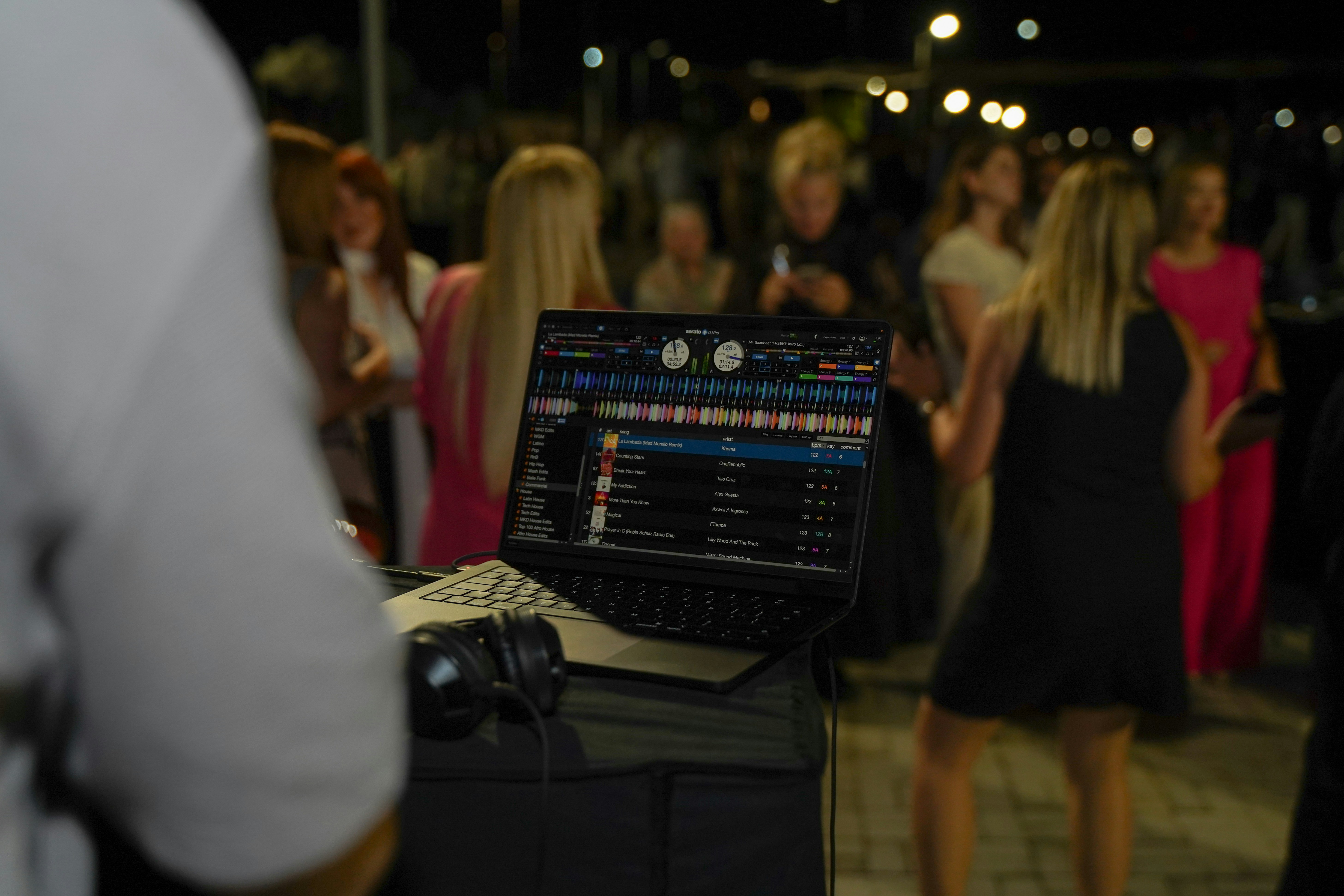 DJ Booth at Networked Night: A DJ laptop Pulses in Focus