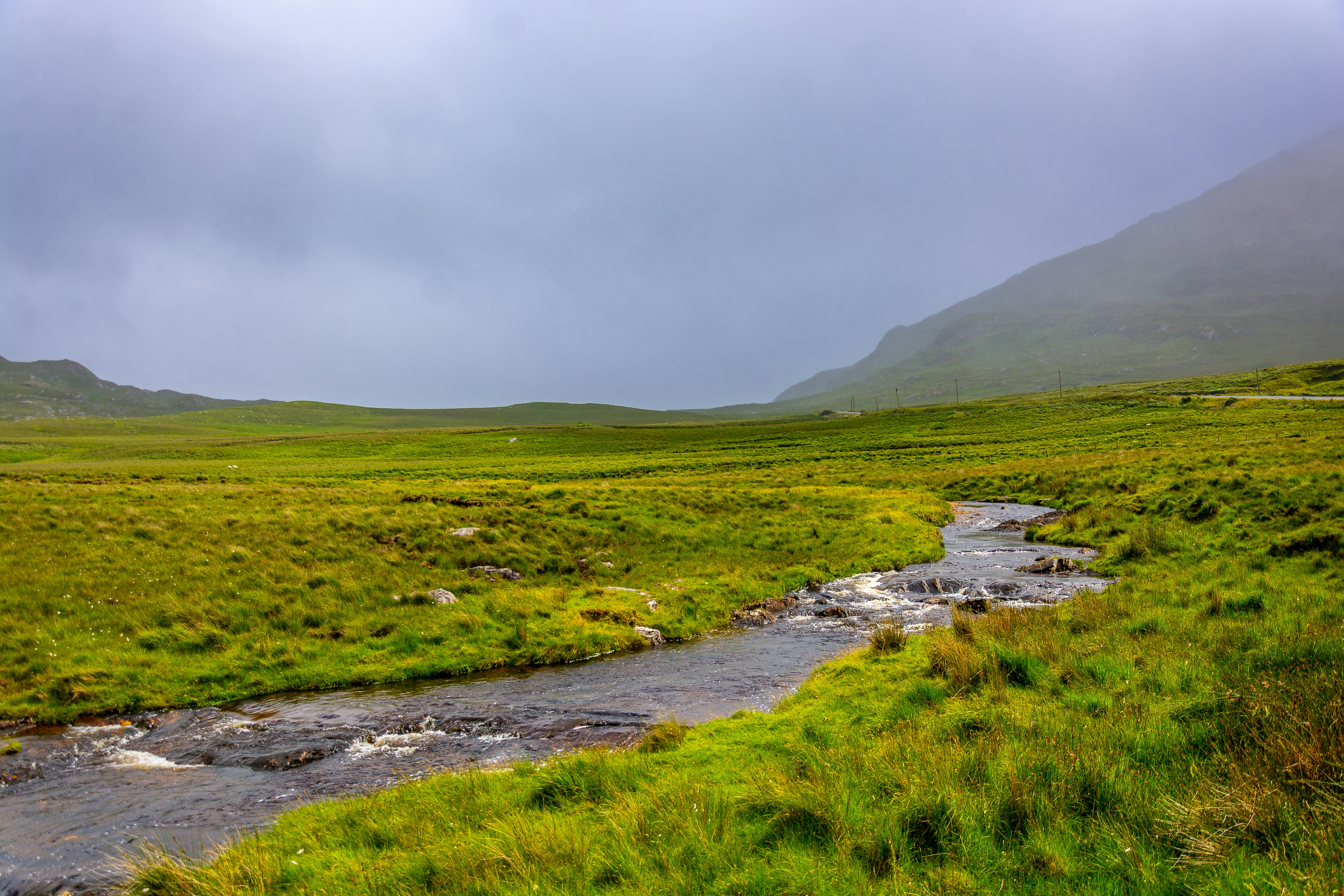 Ribbon of Stream Through Moors Under Misty Hills