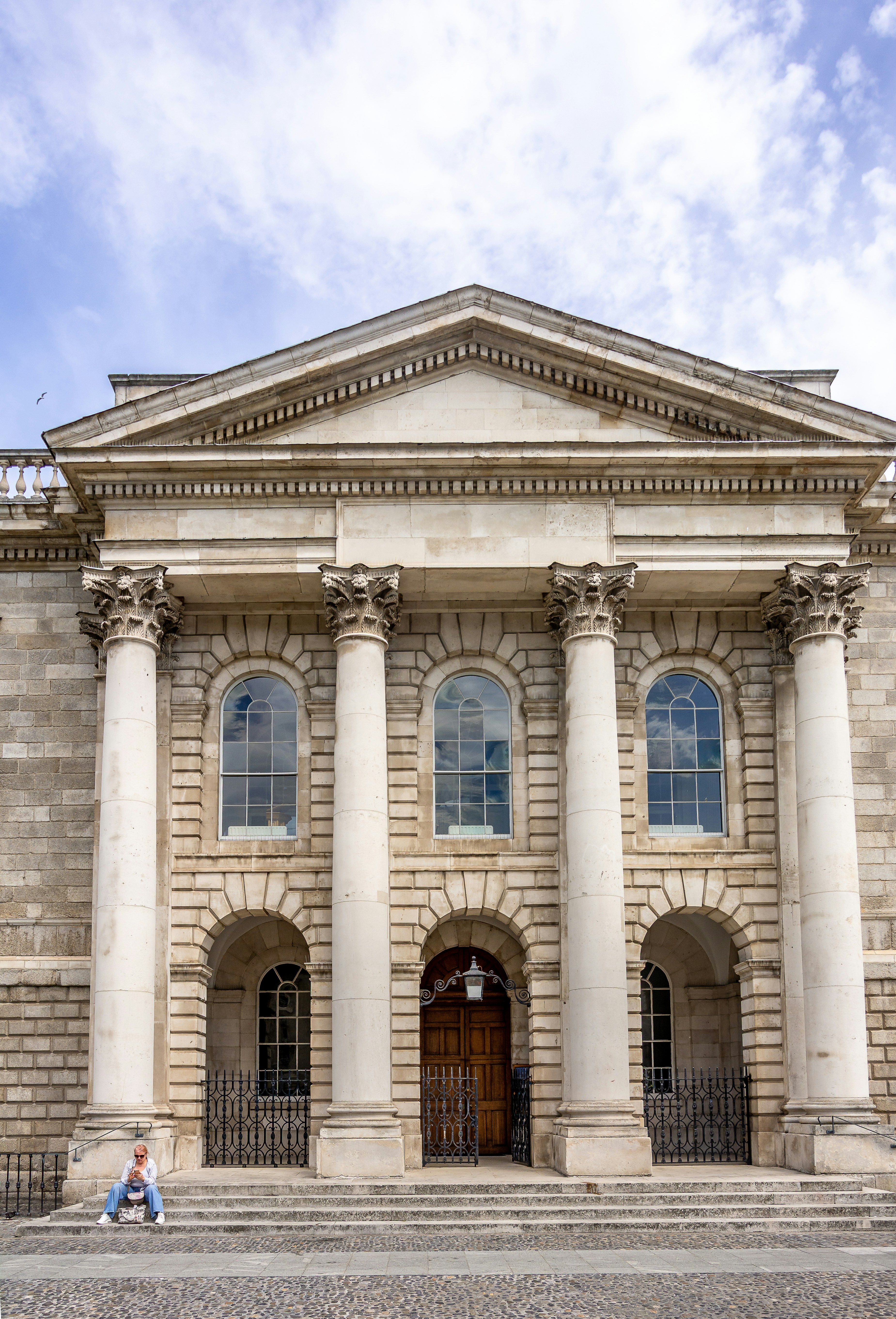 Granite Facade of the Civic Hall: Columns, Arches, and a Quiet Bench