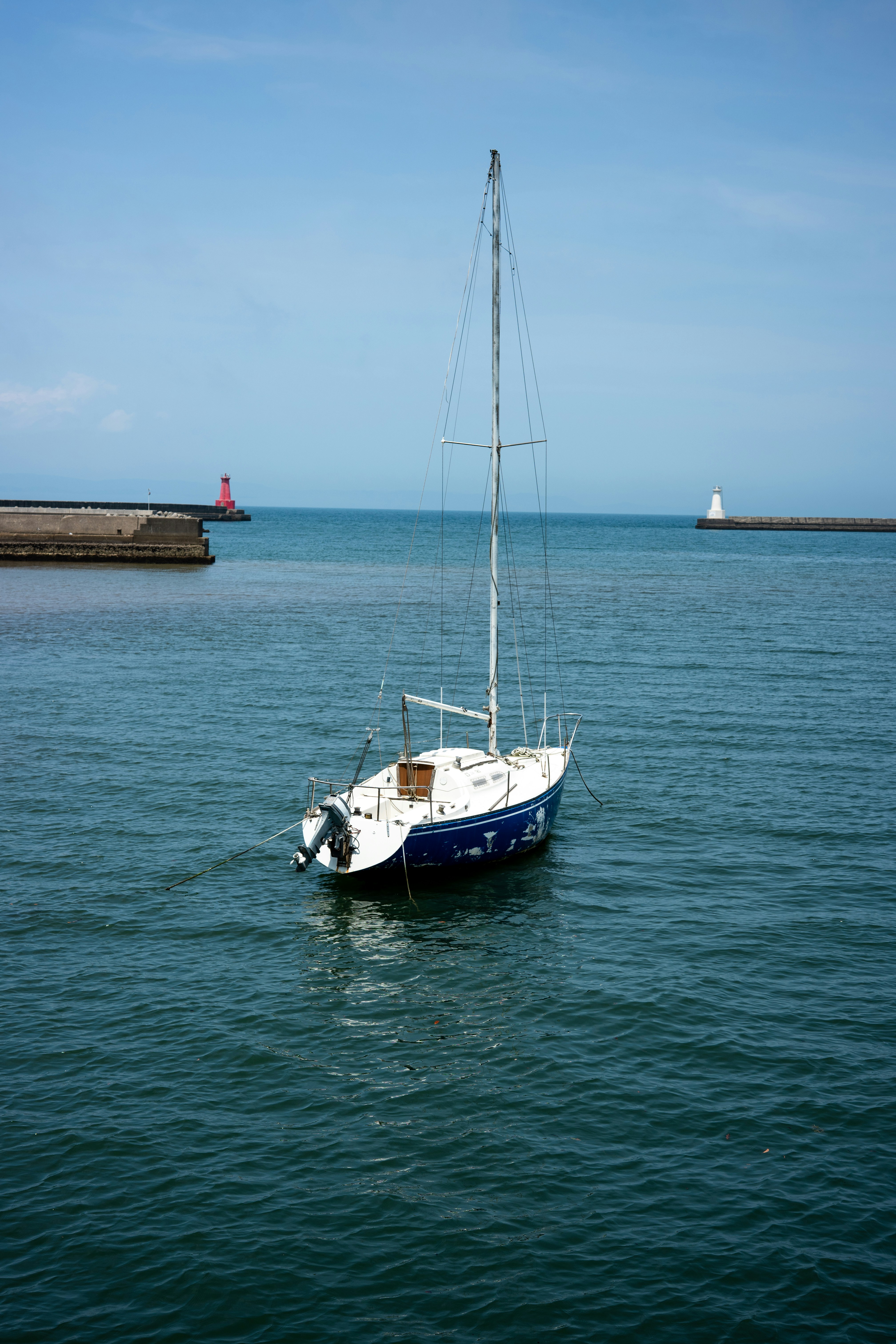 Sailing Quiet: A lone dinghy Anchored in Dappled Coastal Calm