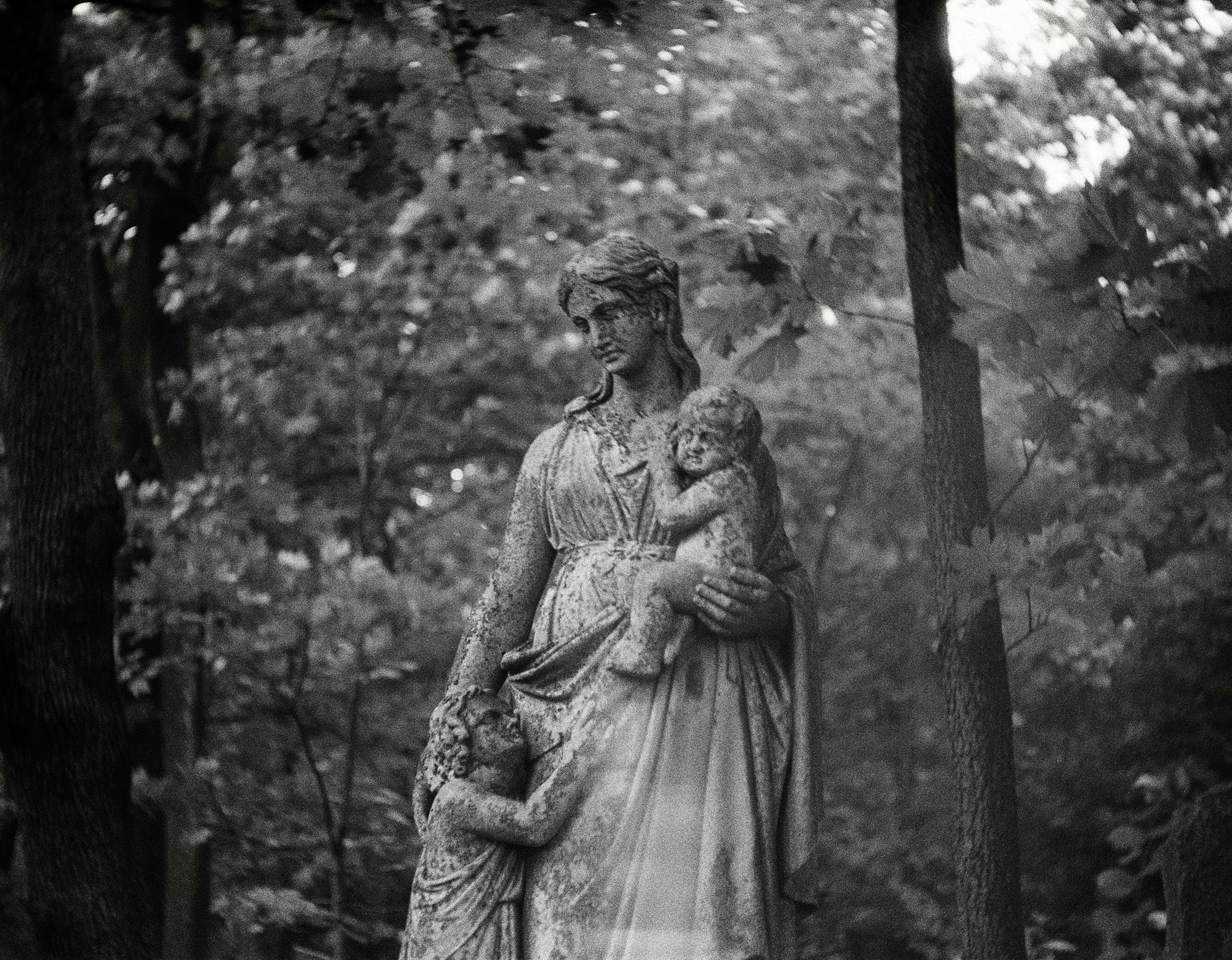 Stone Maiden Among Trees: A Quiet Garden Sentinel