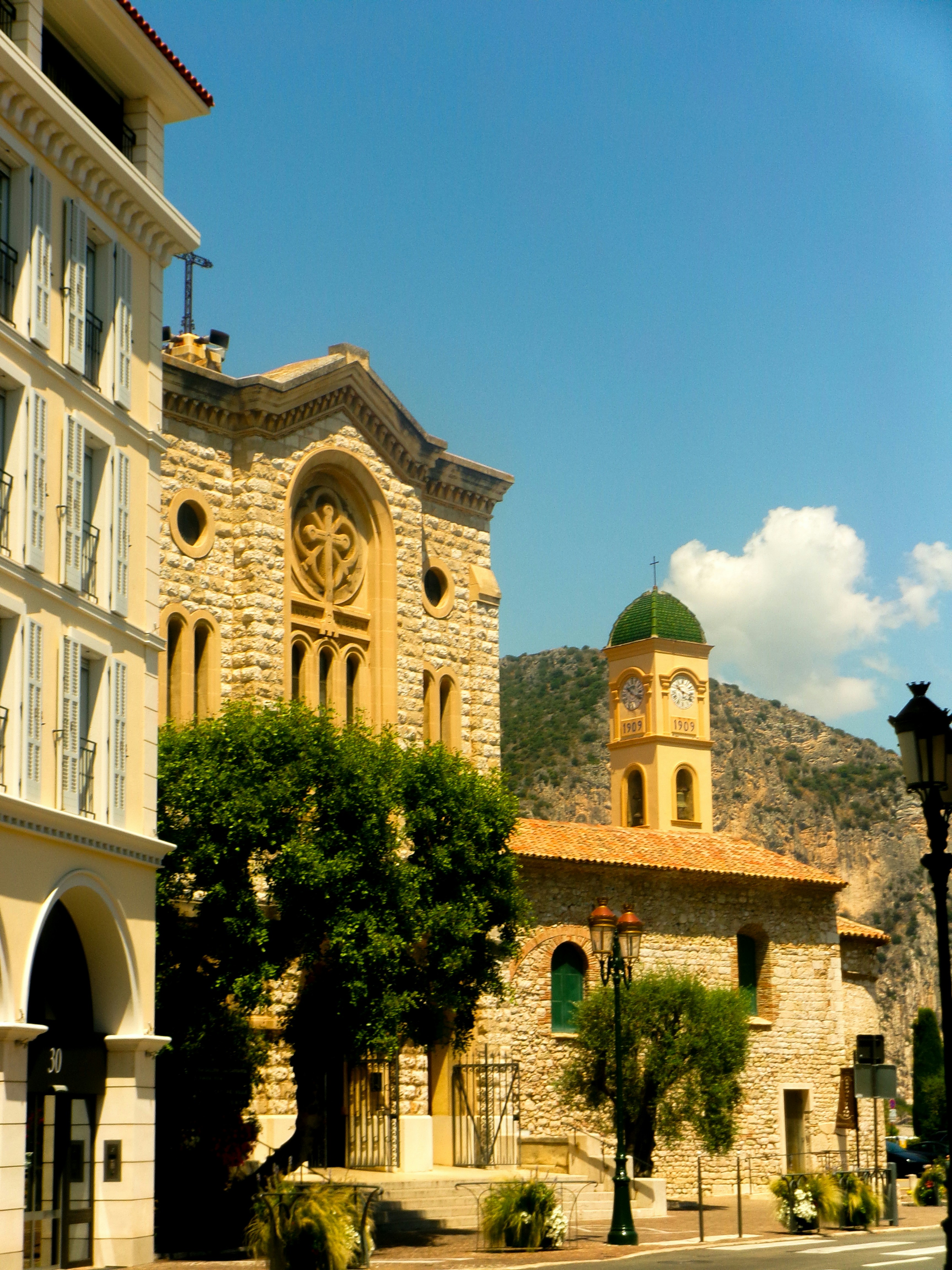 Stone Church, Clock Tower, and Sunlit Facades in a Mediterranean Street