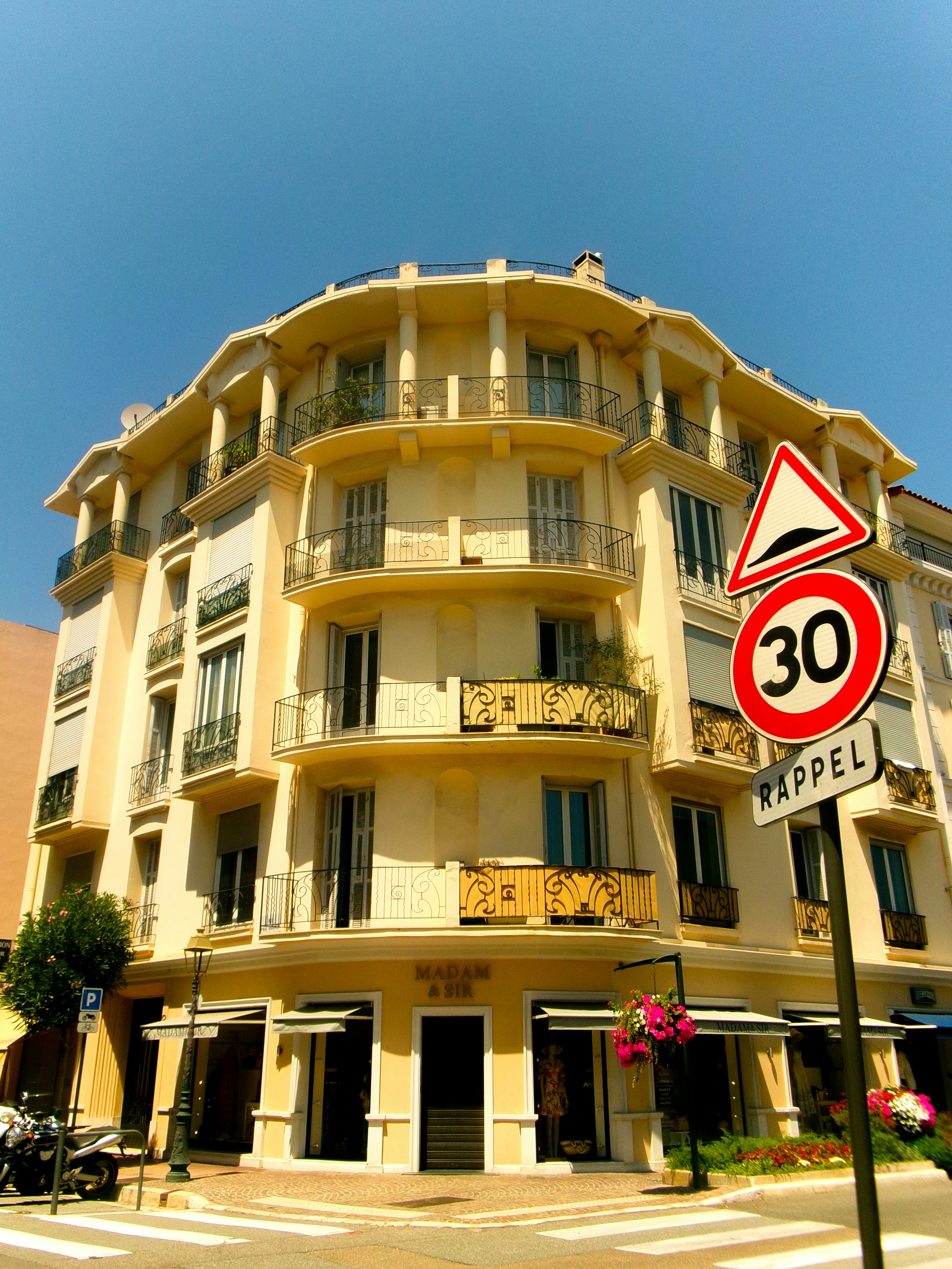 Sunlit Facade with Curve‑Fronted Apartments and Street Signage