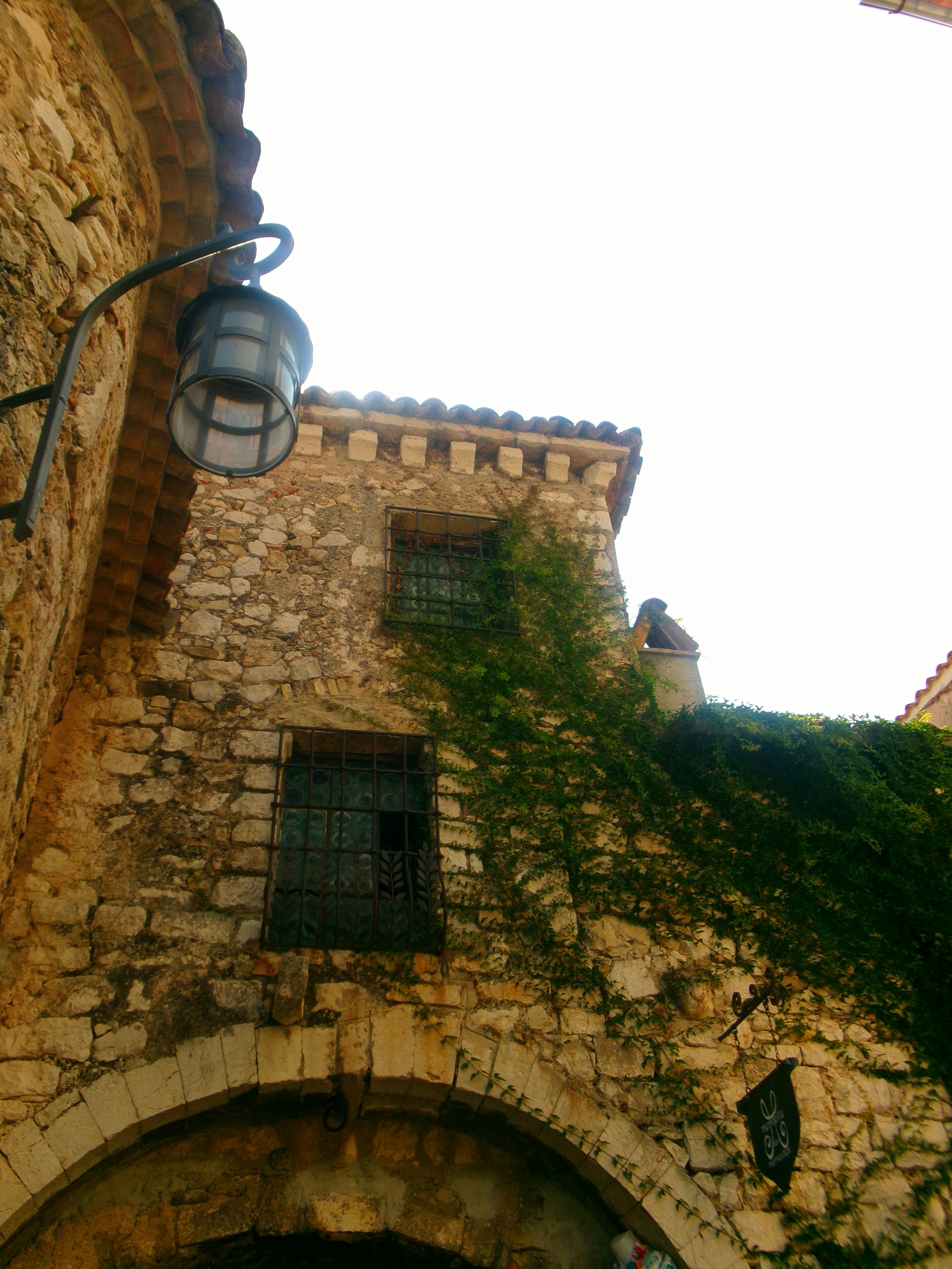 Sunlit Stone Facade with Ivy Cascade and Lantern