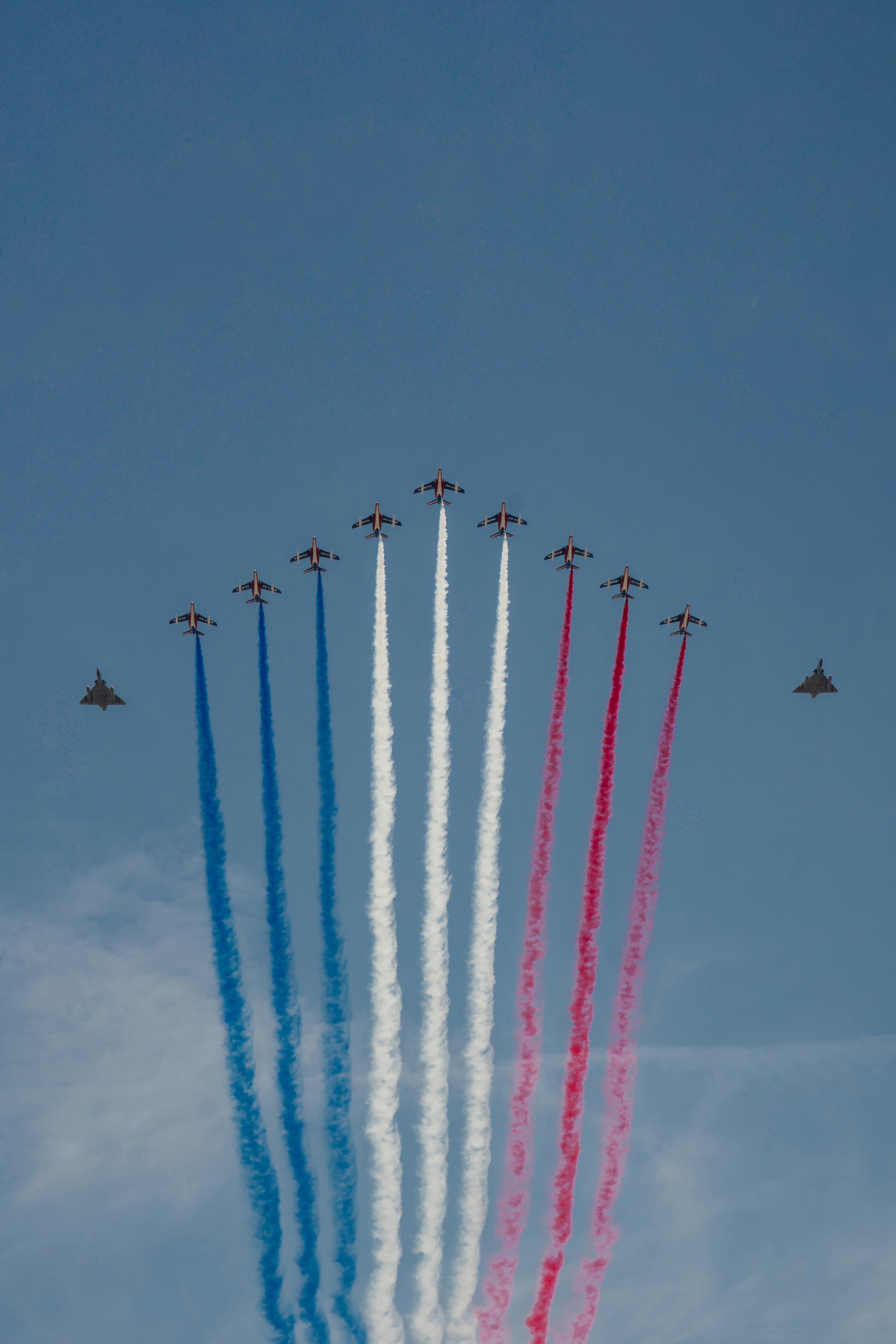 Nine Contrails in Colored Mist Over a Clear Sky