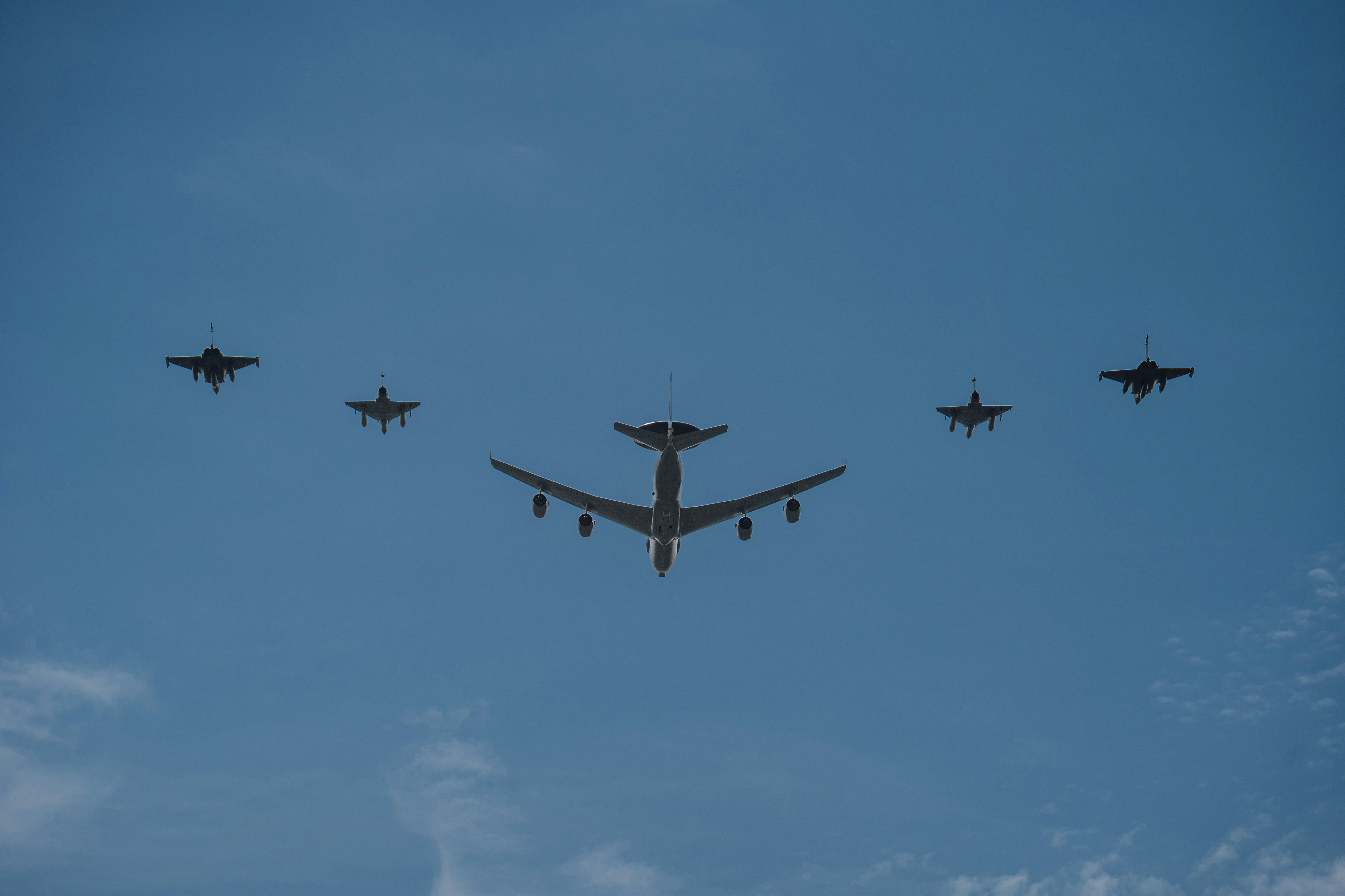Wing Vanguard: Aerial Formation of Four Jets Surrounding a Central Transport