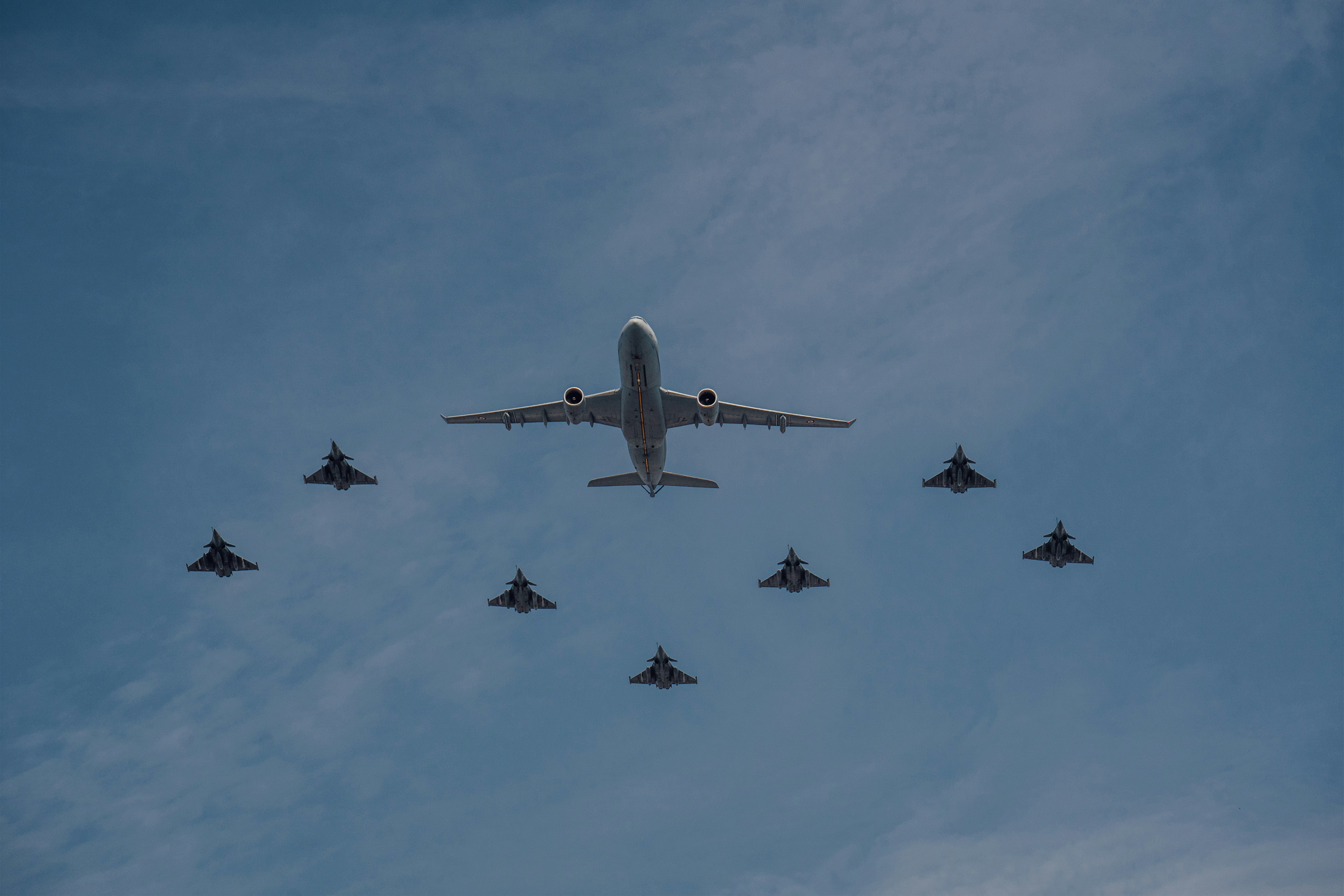 V-formation Majesty: Aerial Squadron Flanking a Passenger Jet