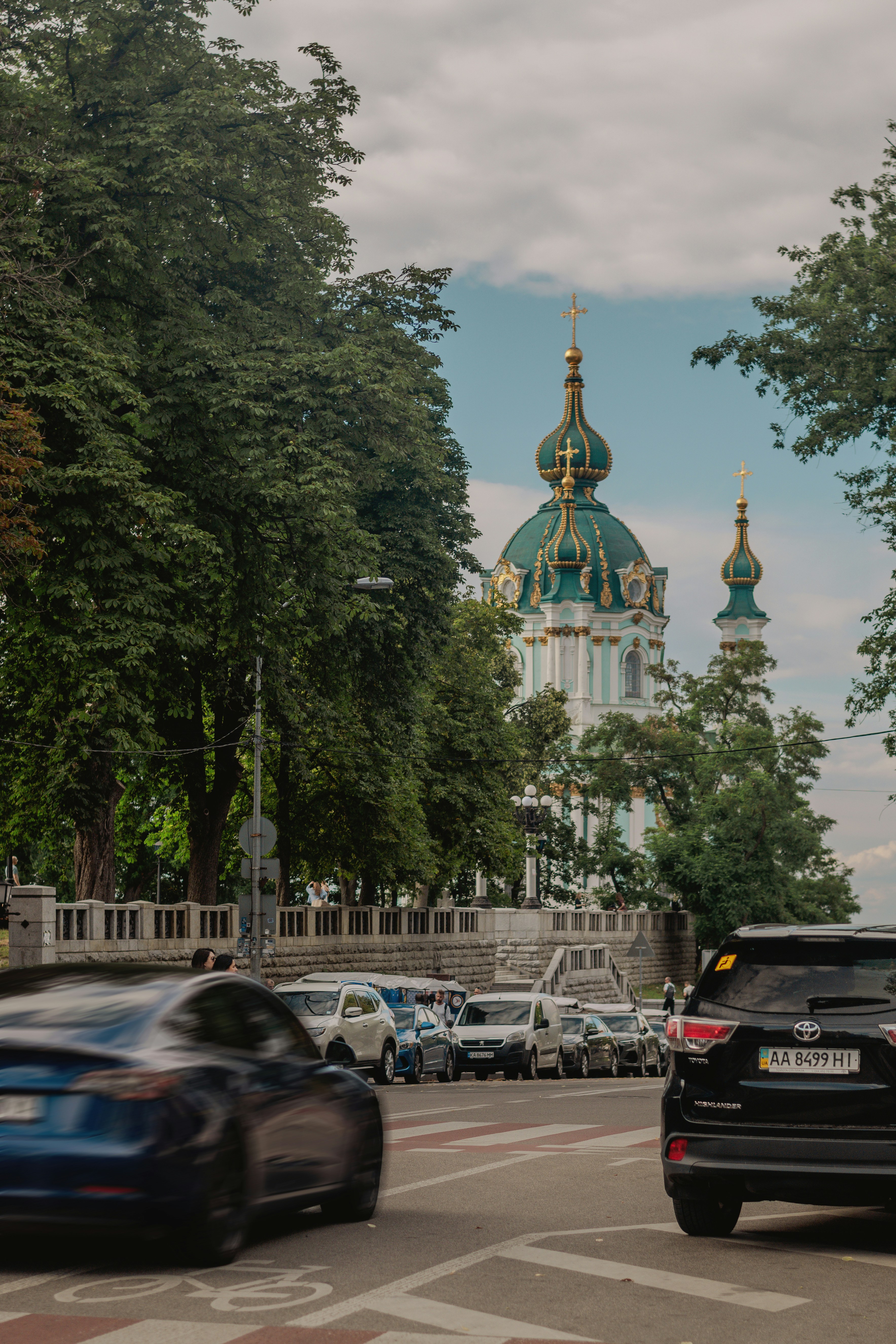 Cathedral Crowned in Green and Gold Rising Over a City Street