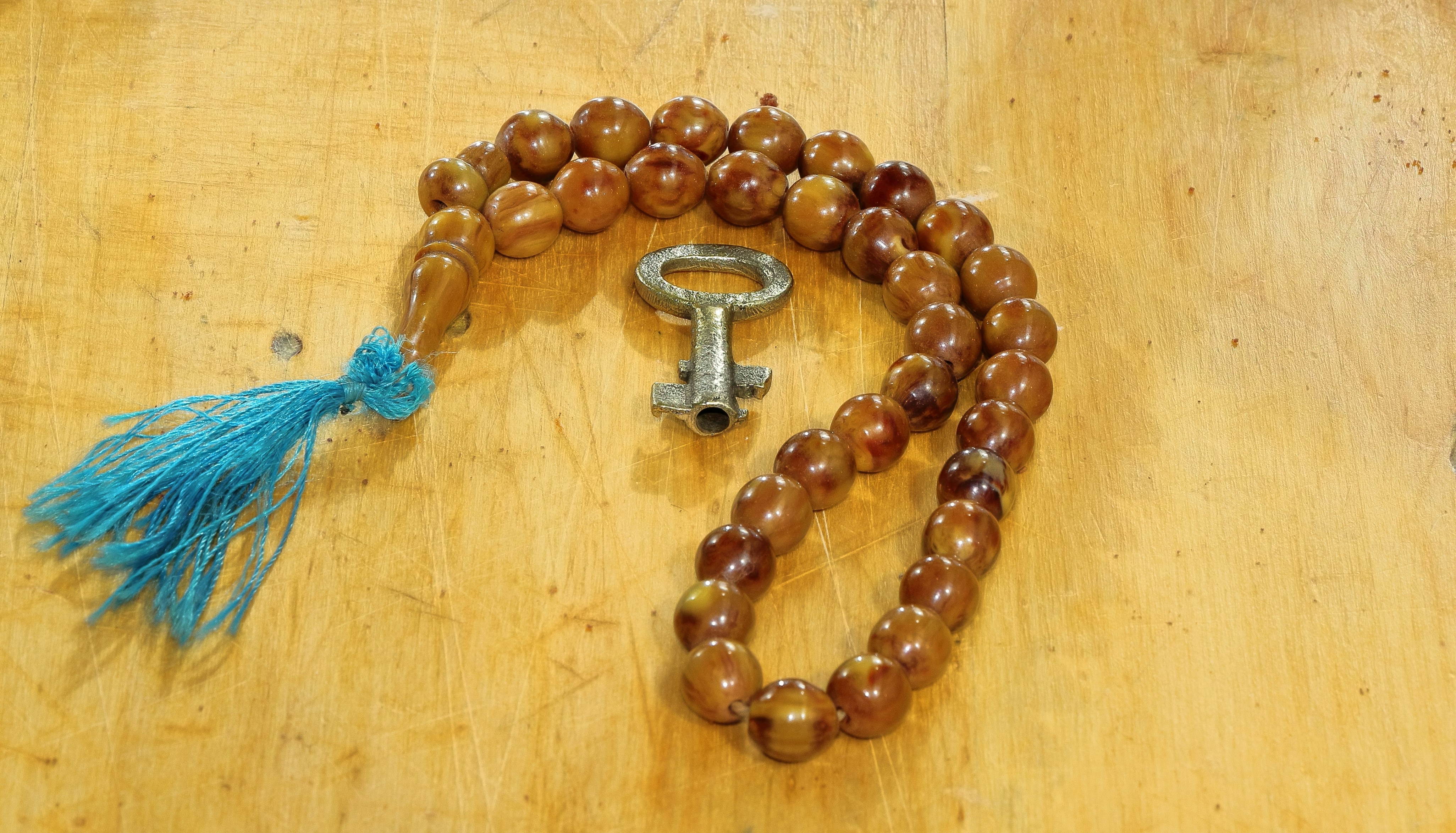 Beaded Key and Tassel: A Glinting Moment on Warm Wood