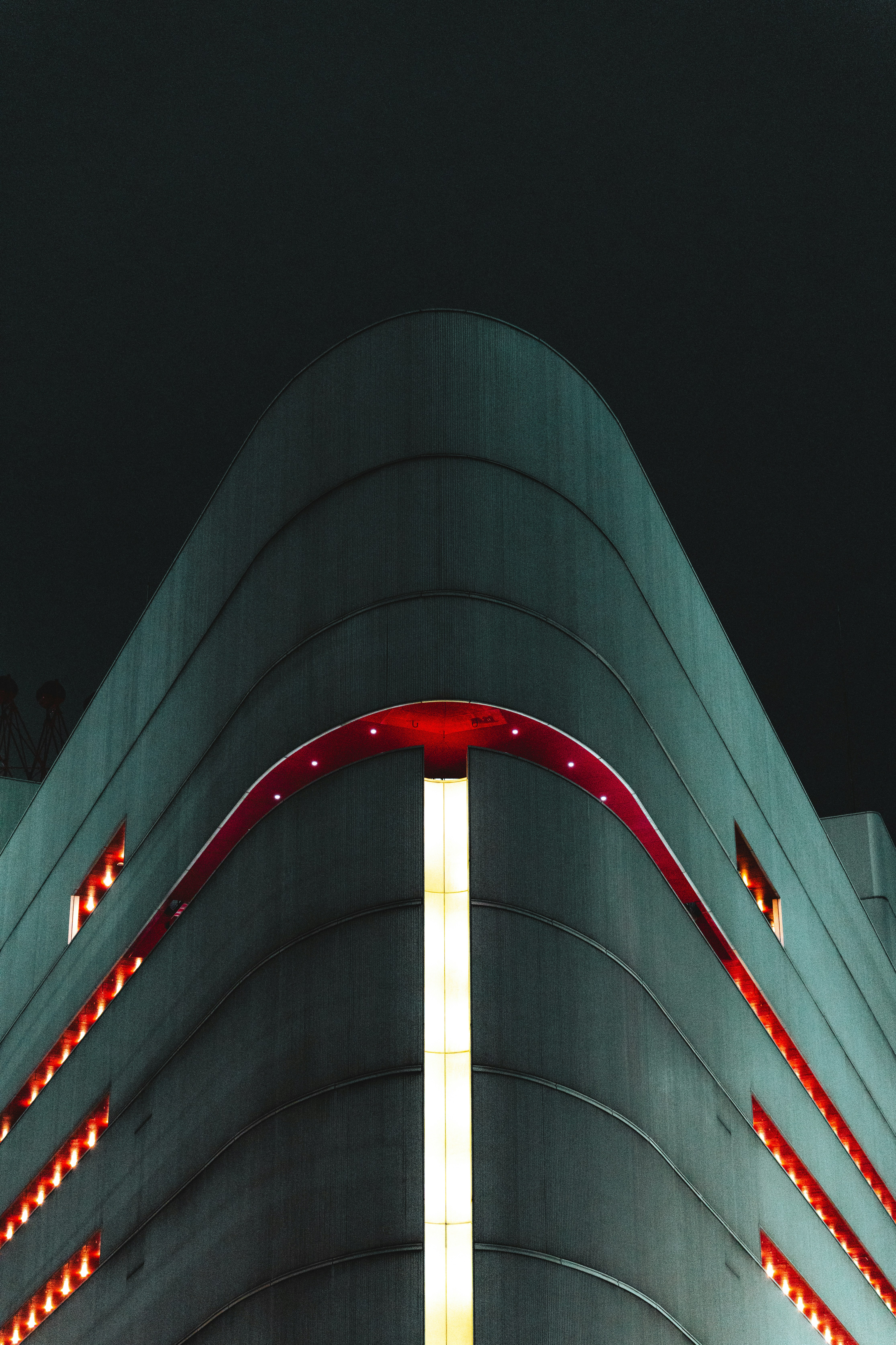 Neon-Red Arc Framing a Night-Folded Facade