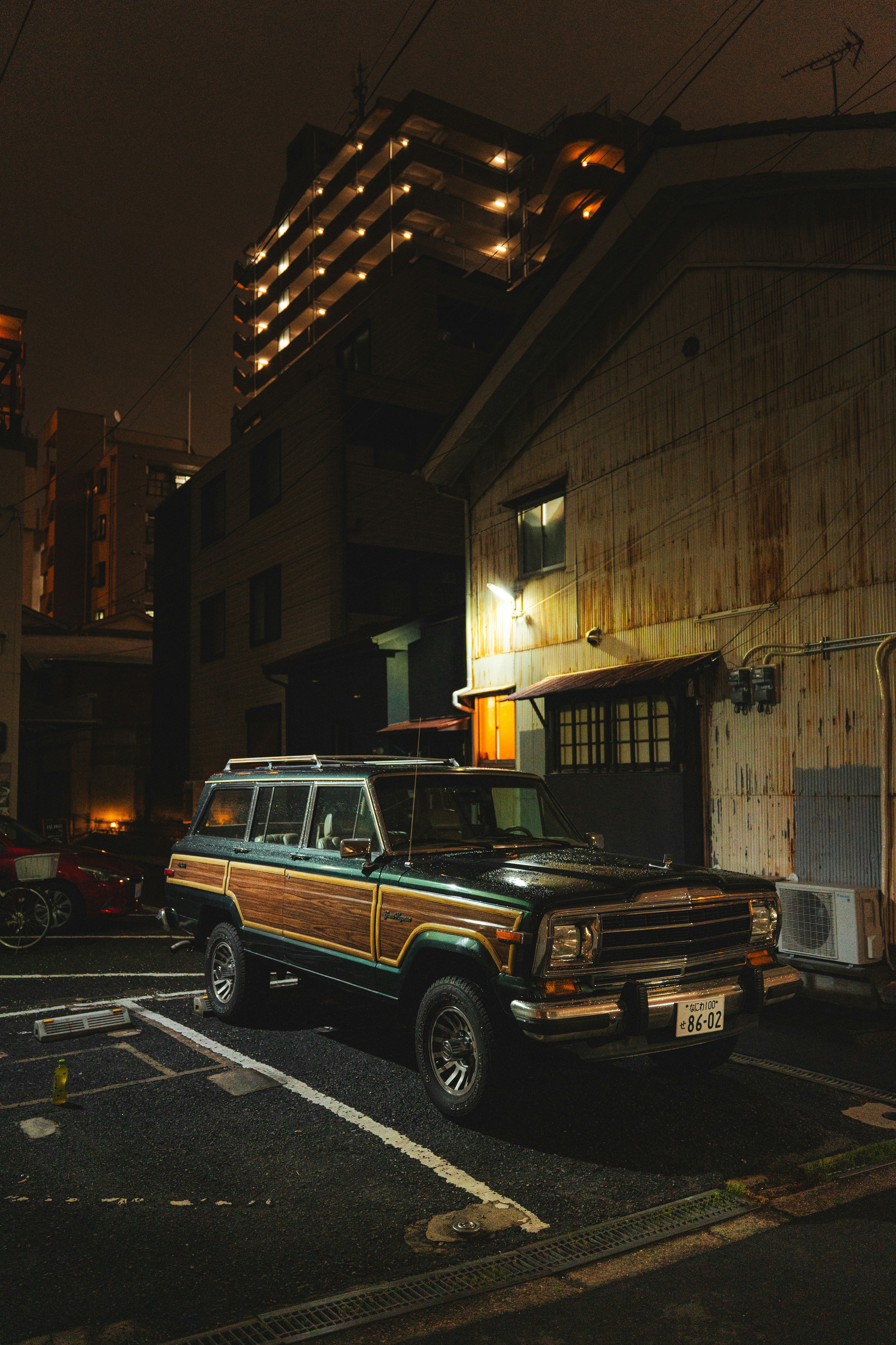 Nighttime Street Scene: Wood-paneled SUV in a Dim Industrial Lot