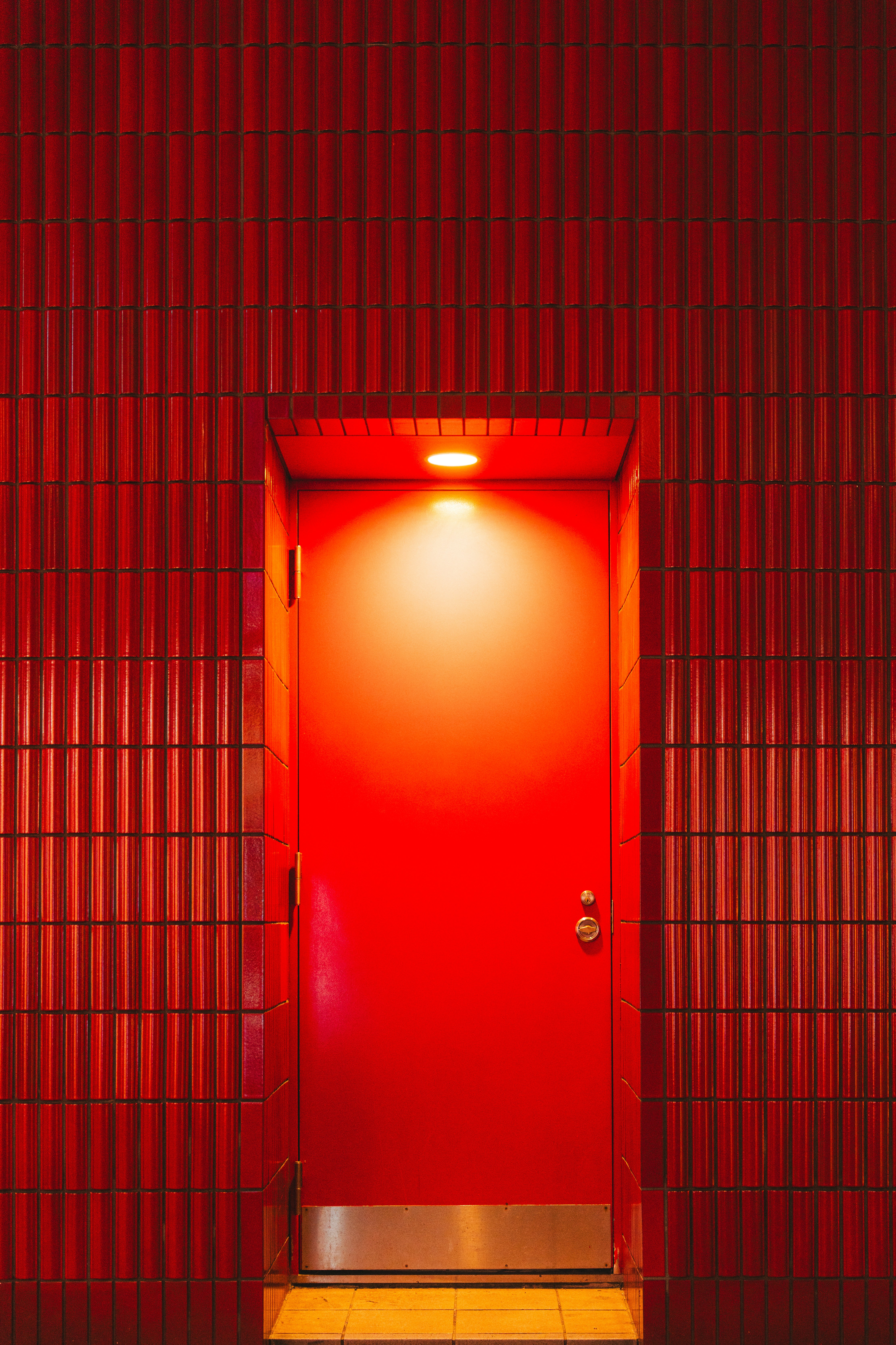 Scarlet Doorway: A Bold Red Entrance Amid Brickwork