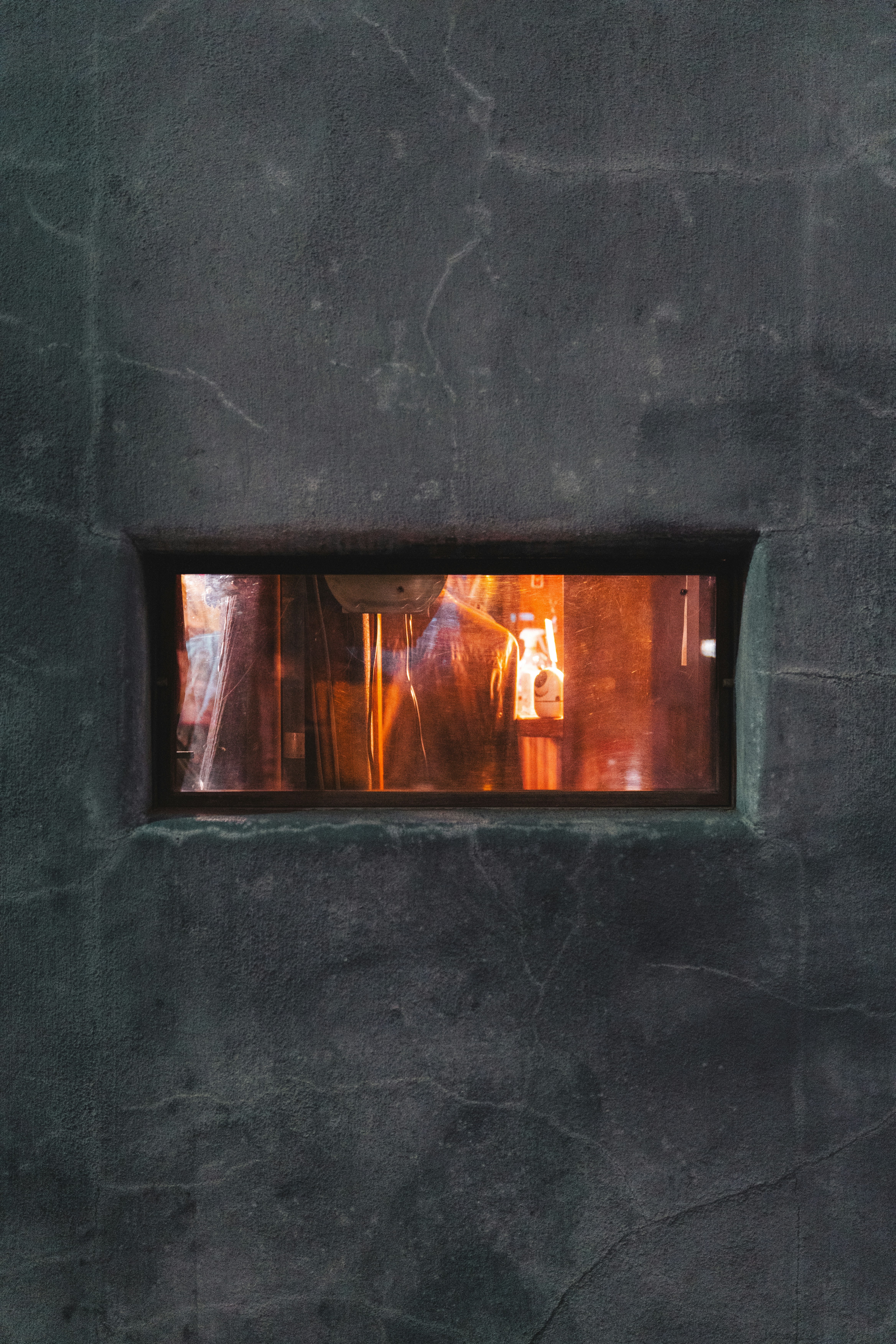 Glowing Window Through a Darkened Facade