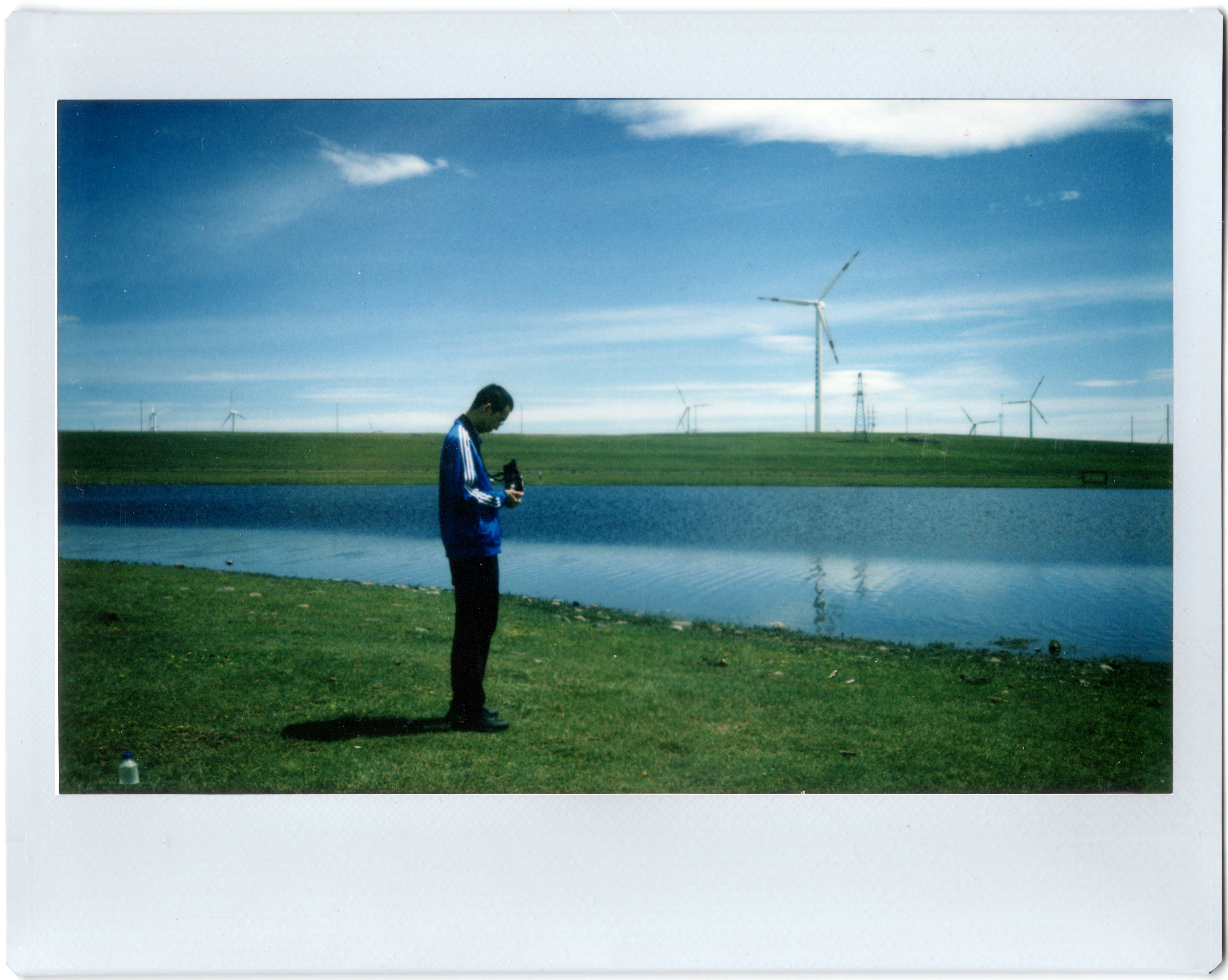 Remote operator at the water’s edge under wind turbines