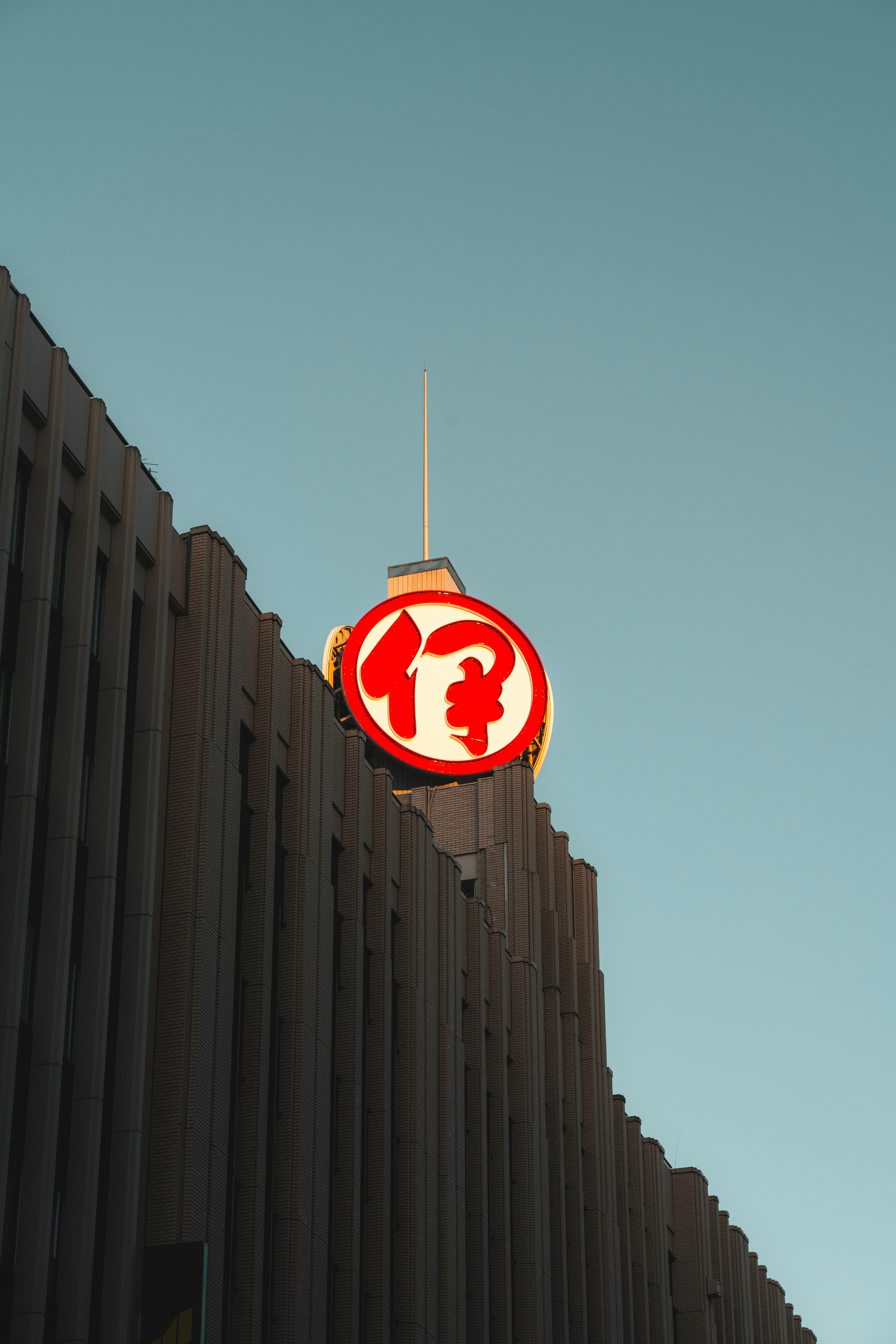 Circular Red Sign atop a Neon-Outlined Facade