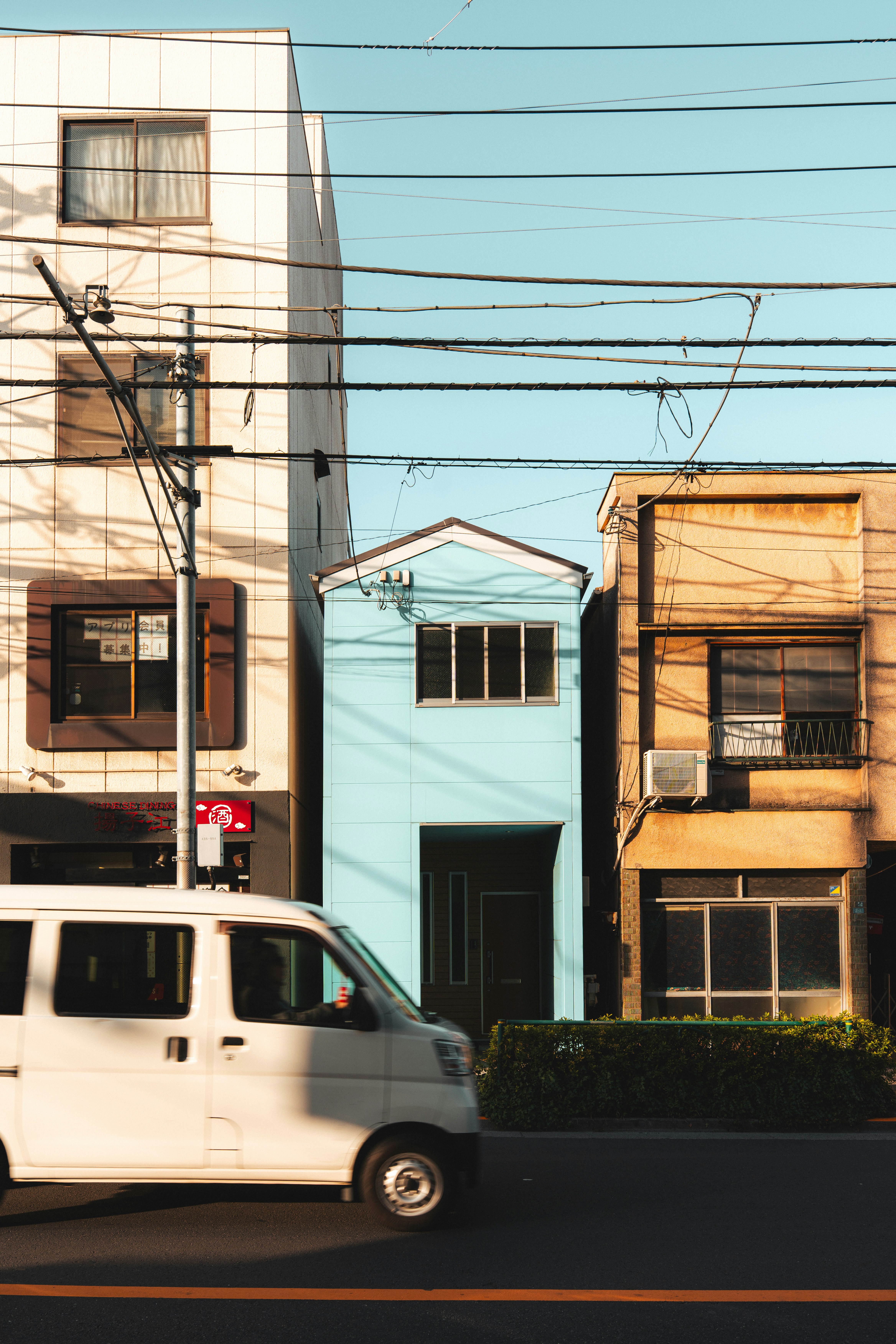 Pastel Central: A Sunlit Street with a Bright Blue Facade