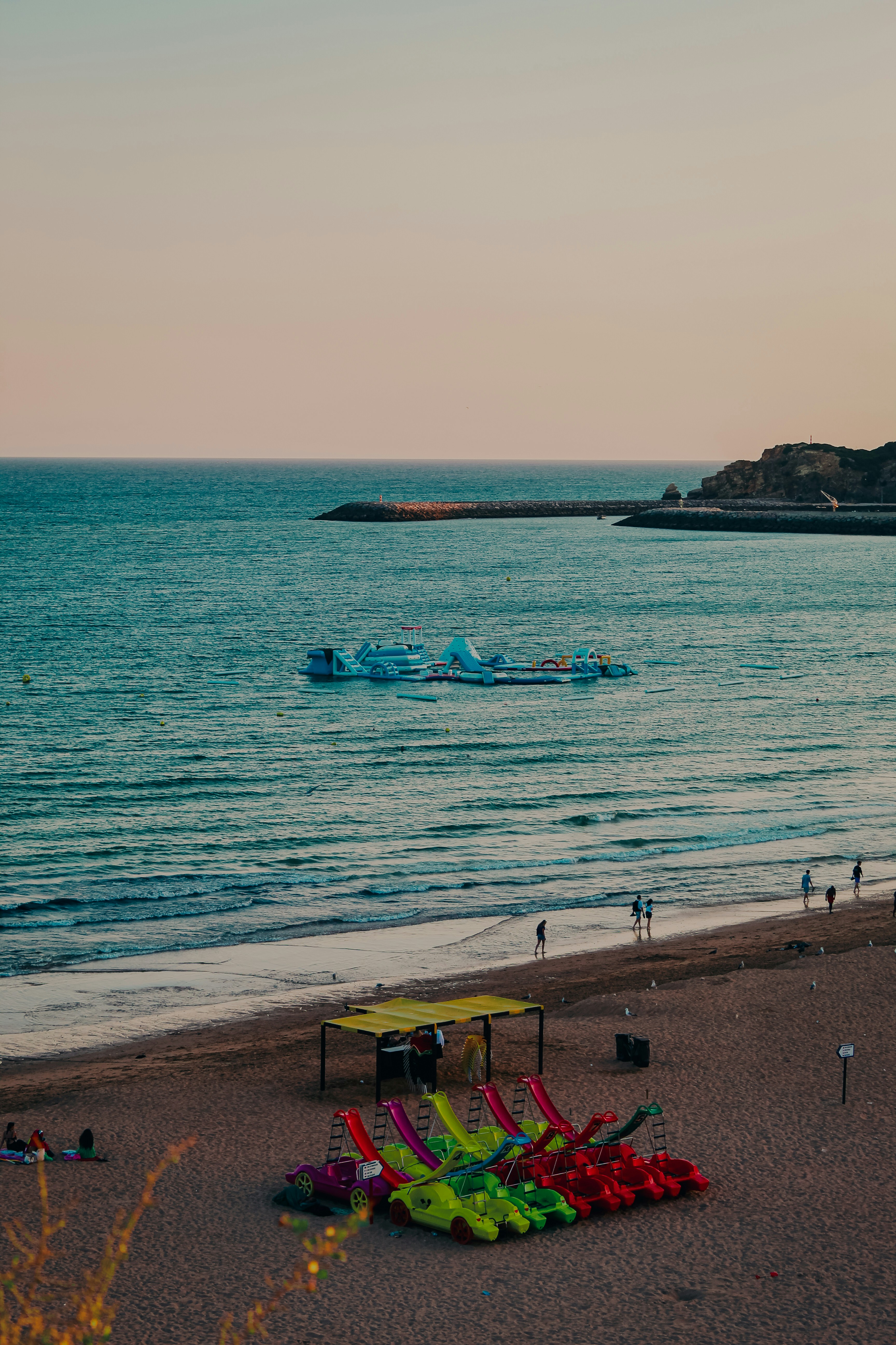 Brightly Colored Beach Toys Sit Idle as Calm Sea Embraces a Quiet Shore