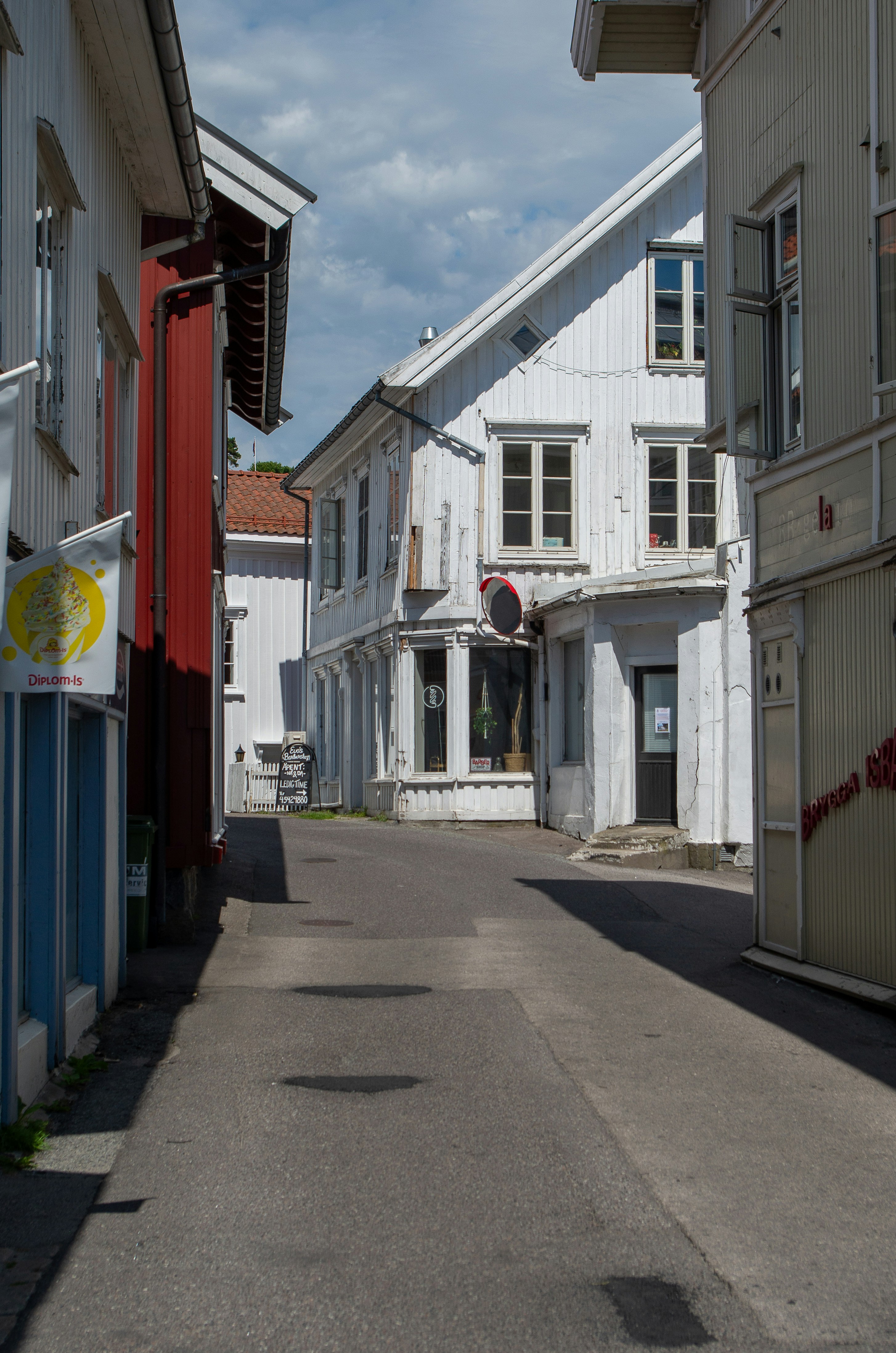 Narrow Nordic Streetway Between Weathered White and Red Facades