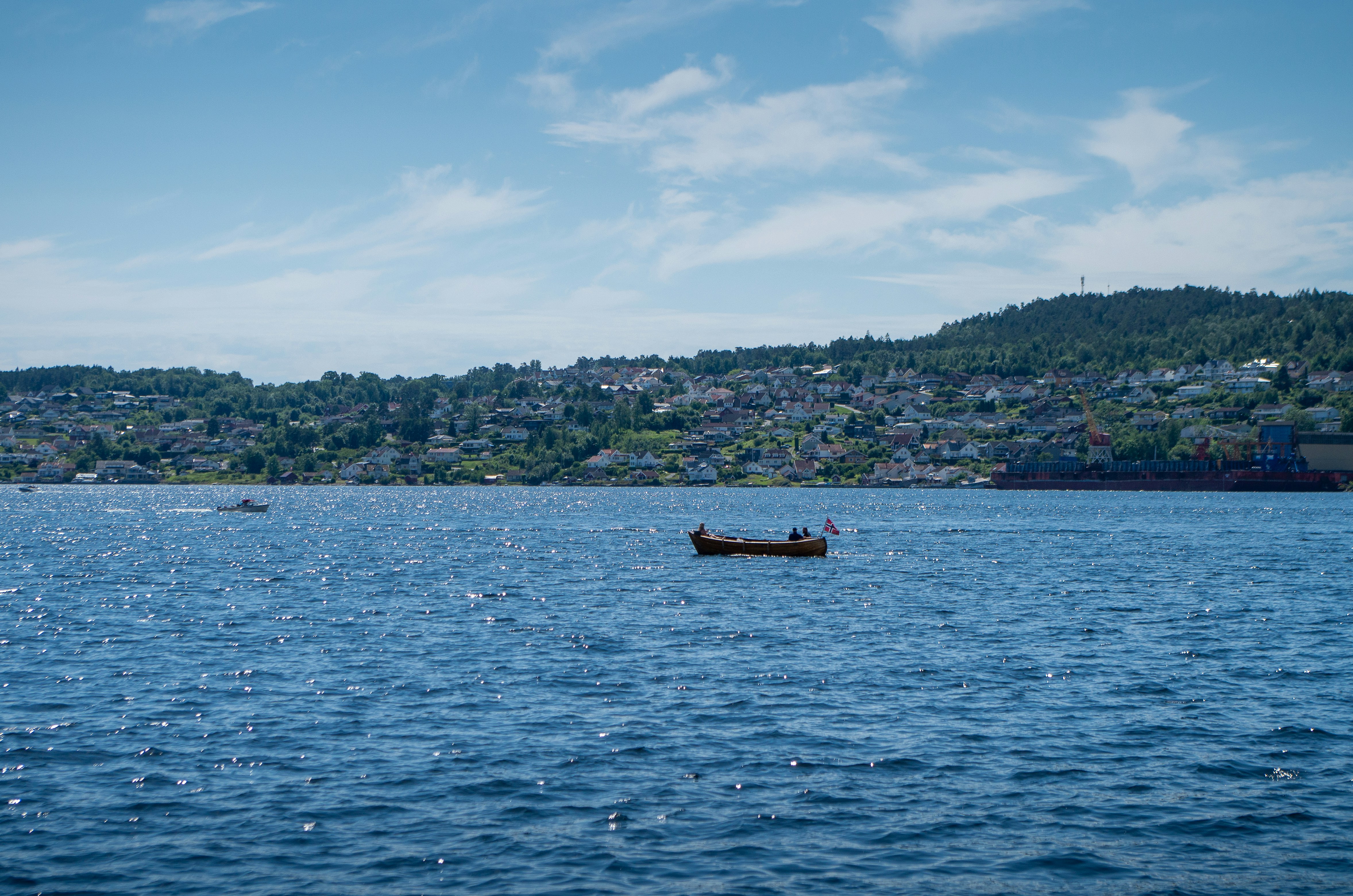 Boat in a Quiet Sea Under a Distant Town
