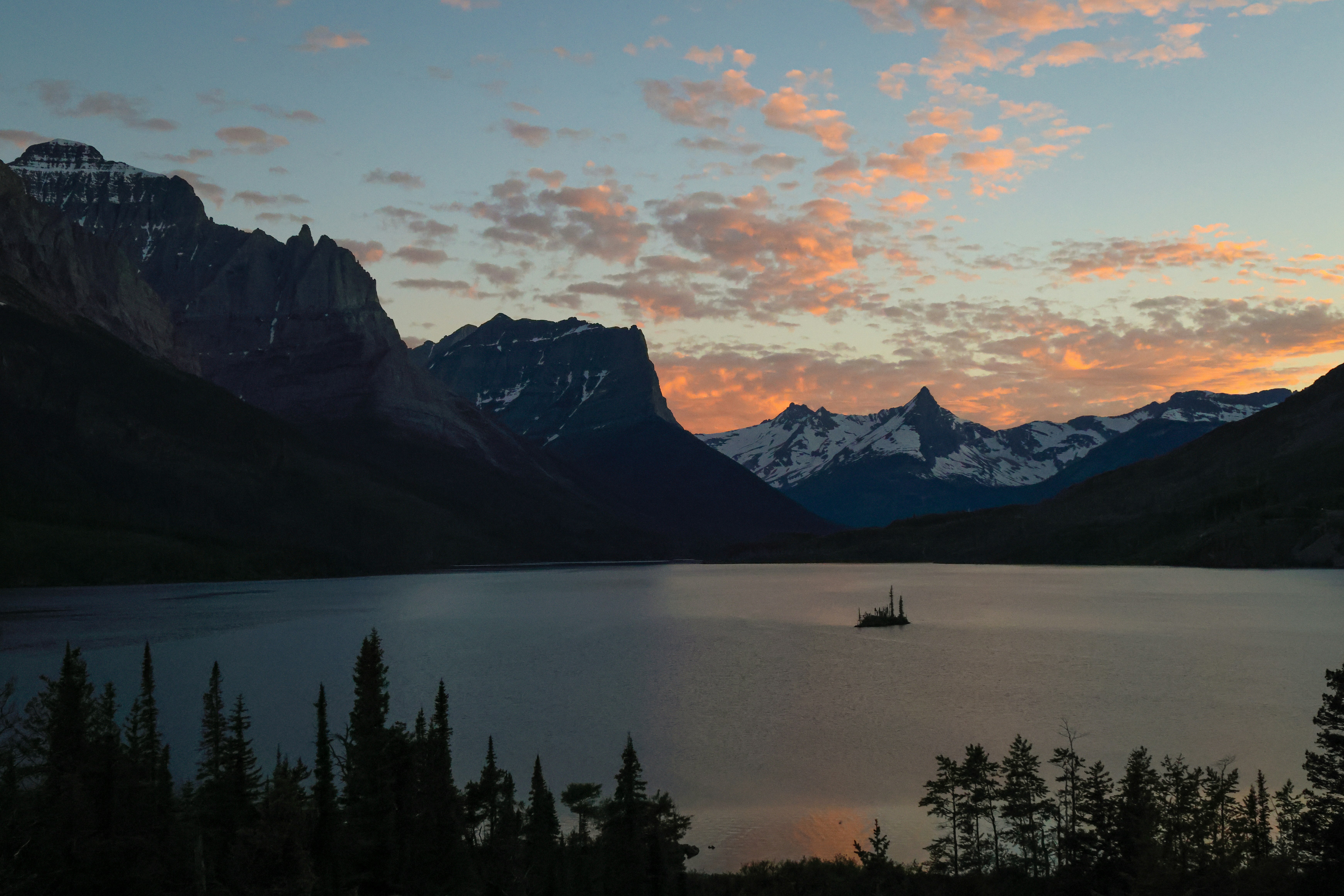 Sunset stillness over a glacier-fed lake beneath jagged peaks