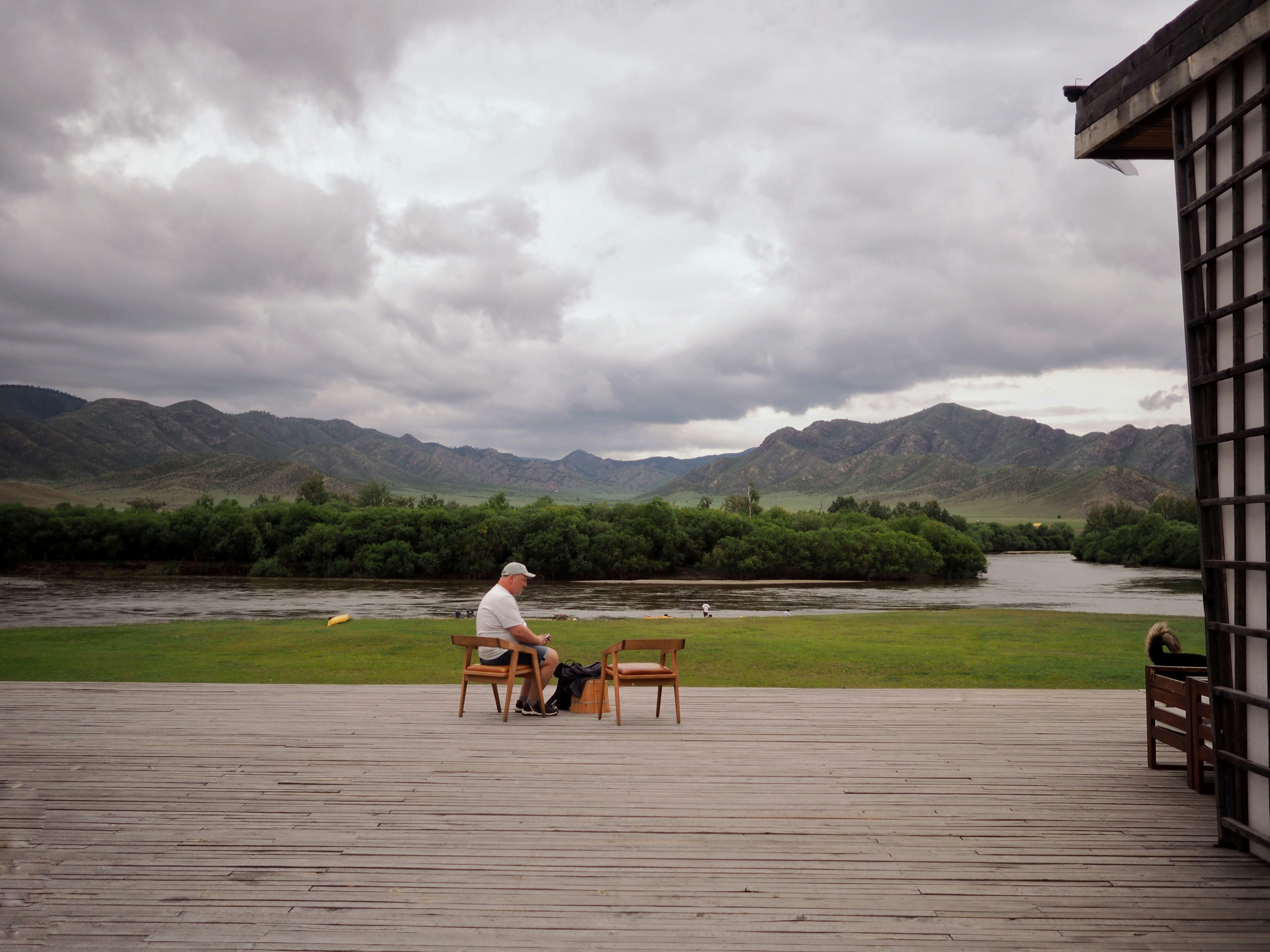 Solitary Angler on the Deck by a Wandering River