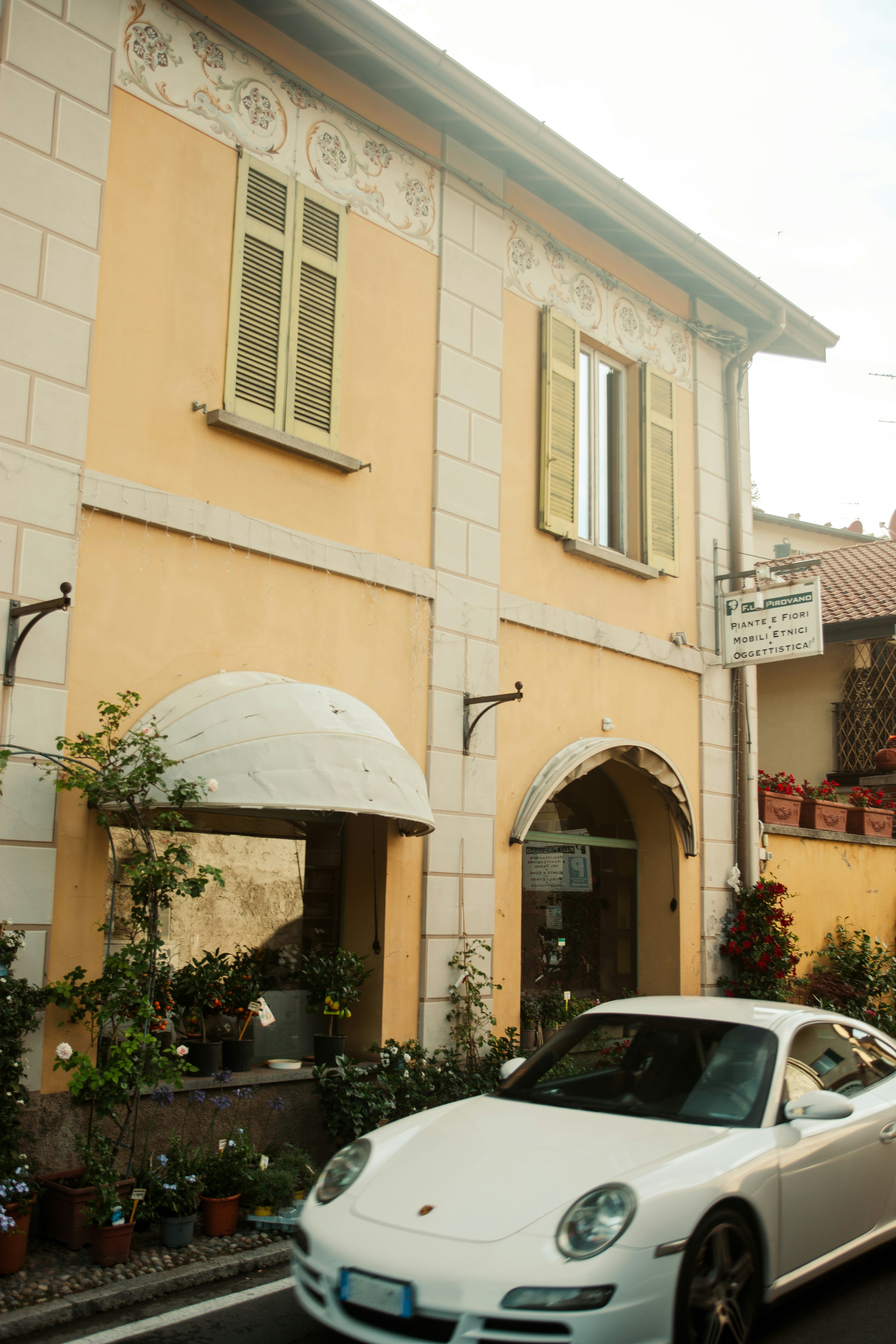 Sunlit Italian Streetfront with a White Porsche Staging in the Shade
