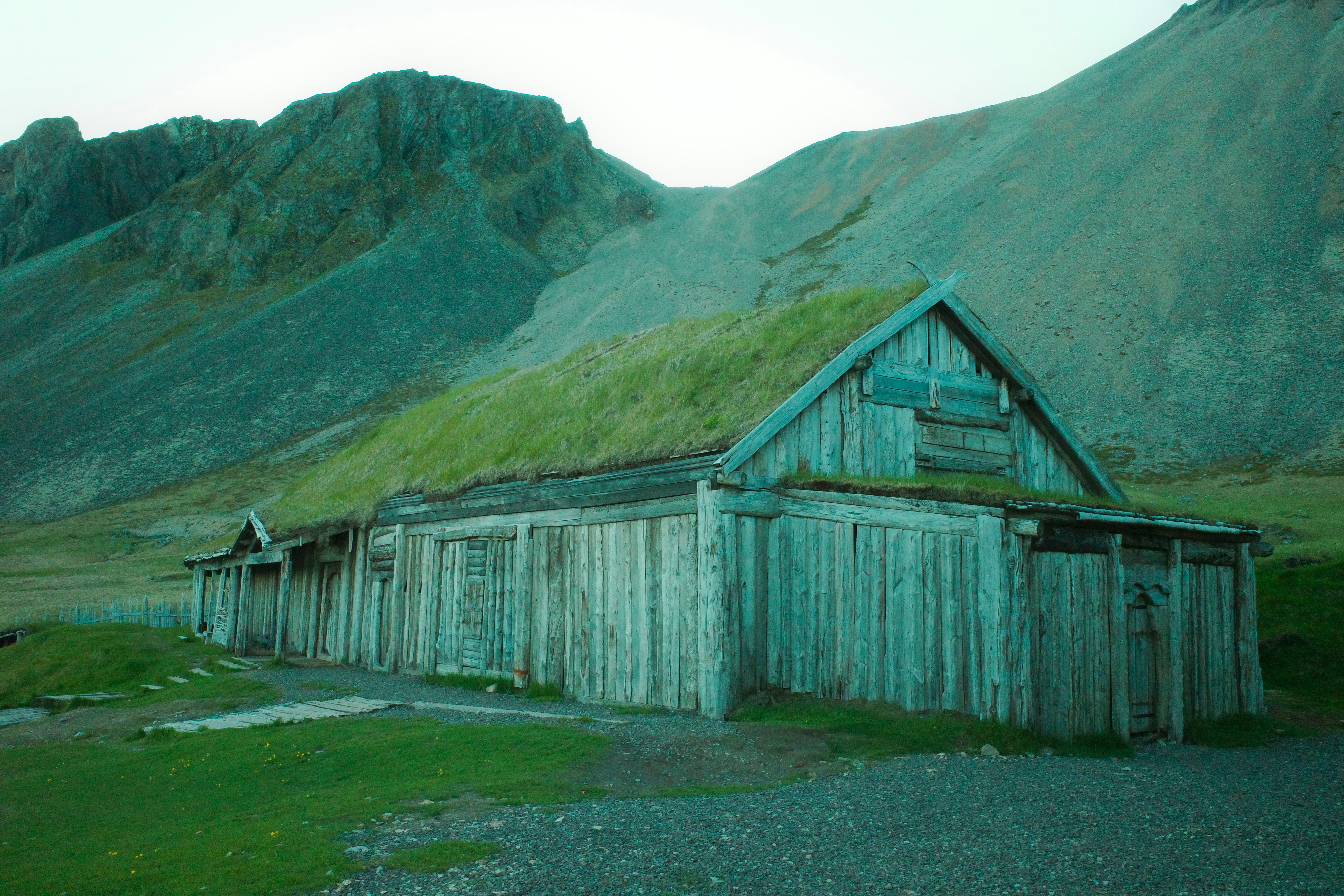 Weathered Dolmens: A Lone Row of Sea-Tide Sheds Under Rugged Peaks