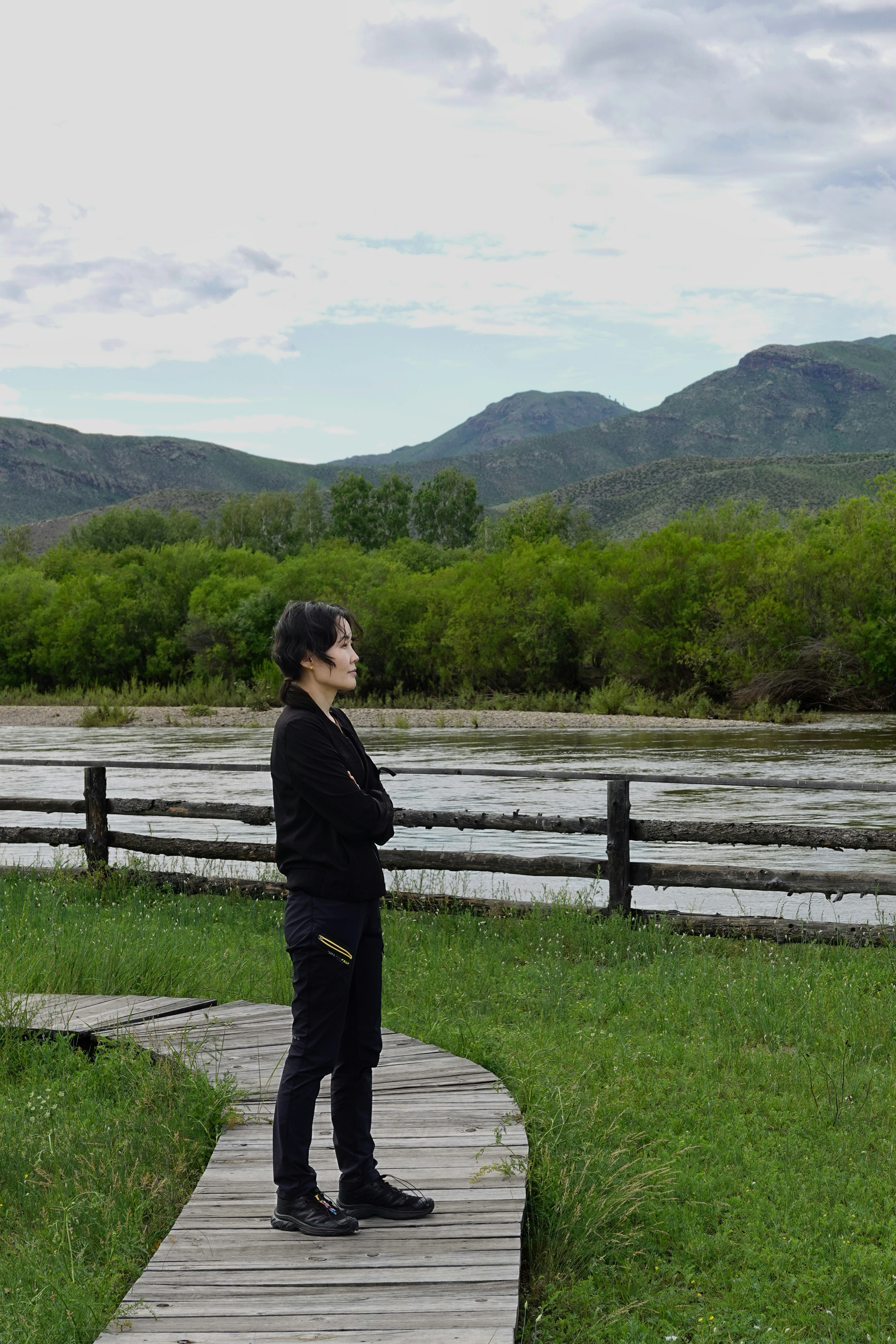 Silhouette on the Boardwalk: A Quiet Portrait by the River
