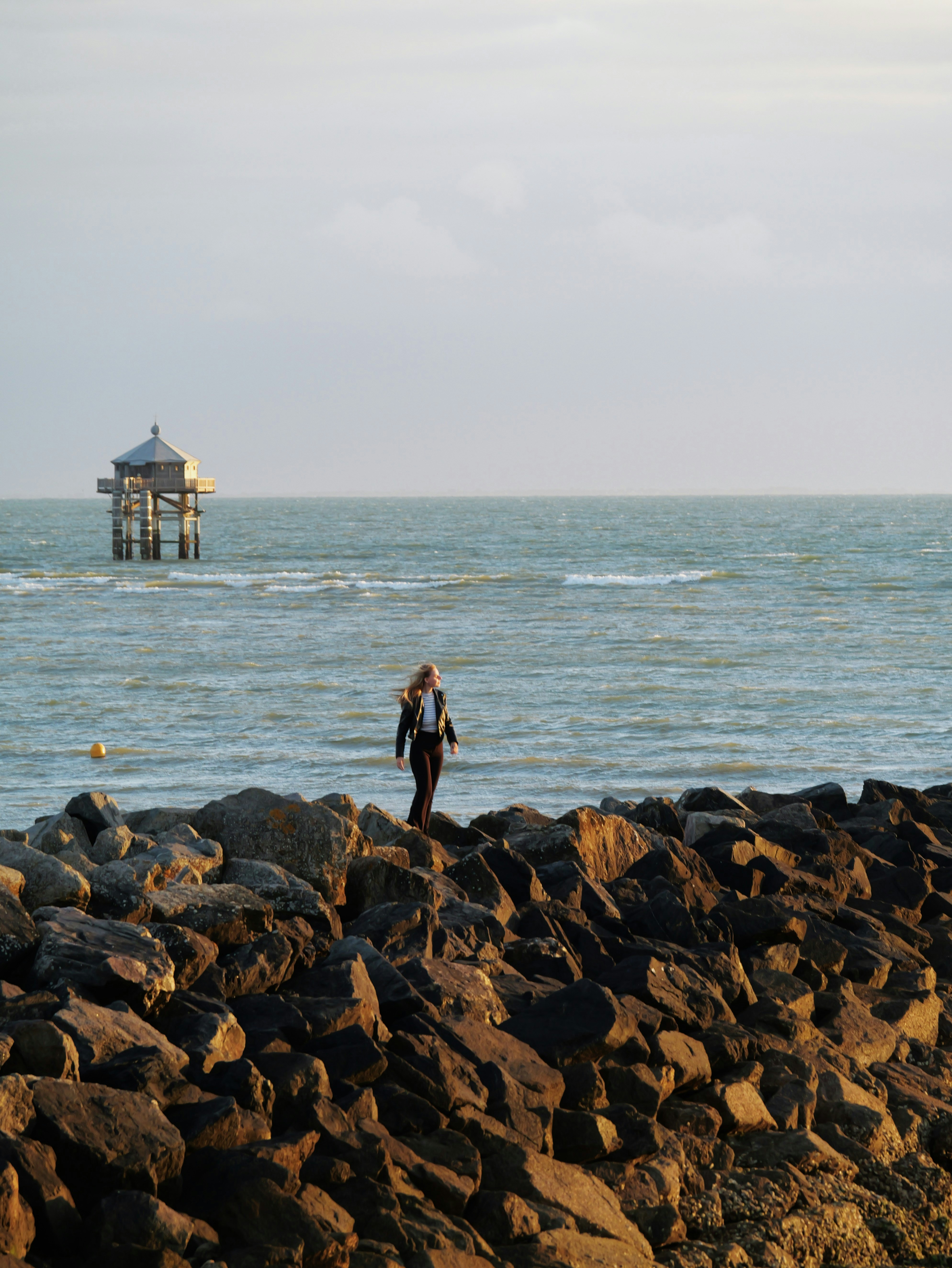 Rocky Path to the Horizon: A Lone Wanderer on the Breakwater