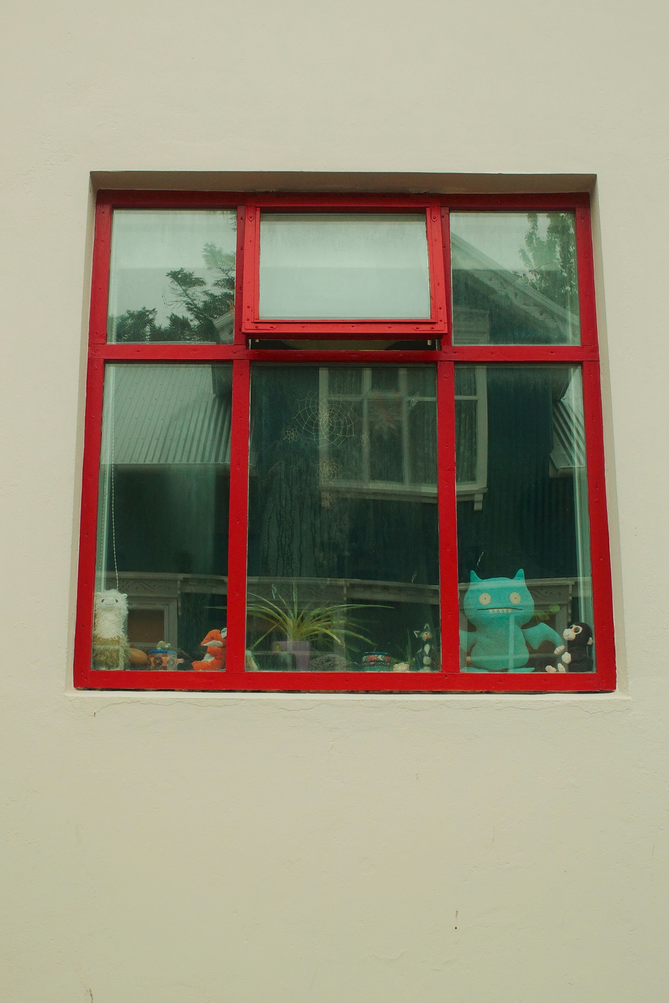 Red-framed Window of Whimsy: Small Figurines Behind Glass