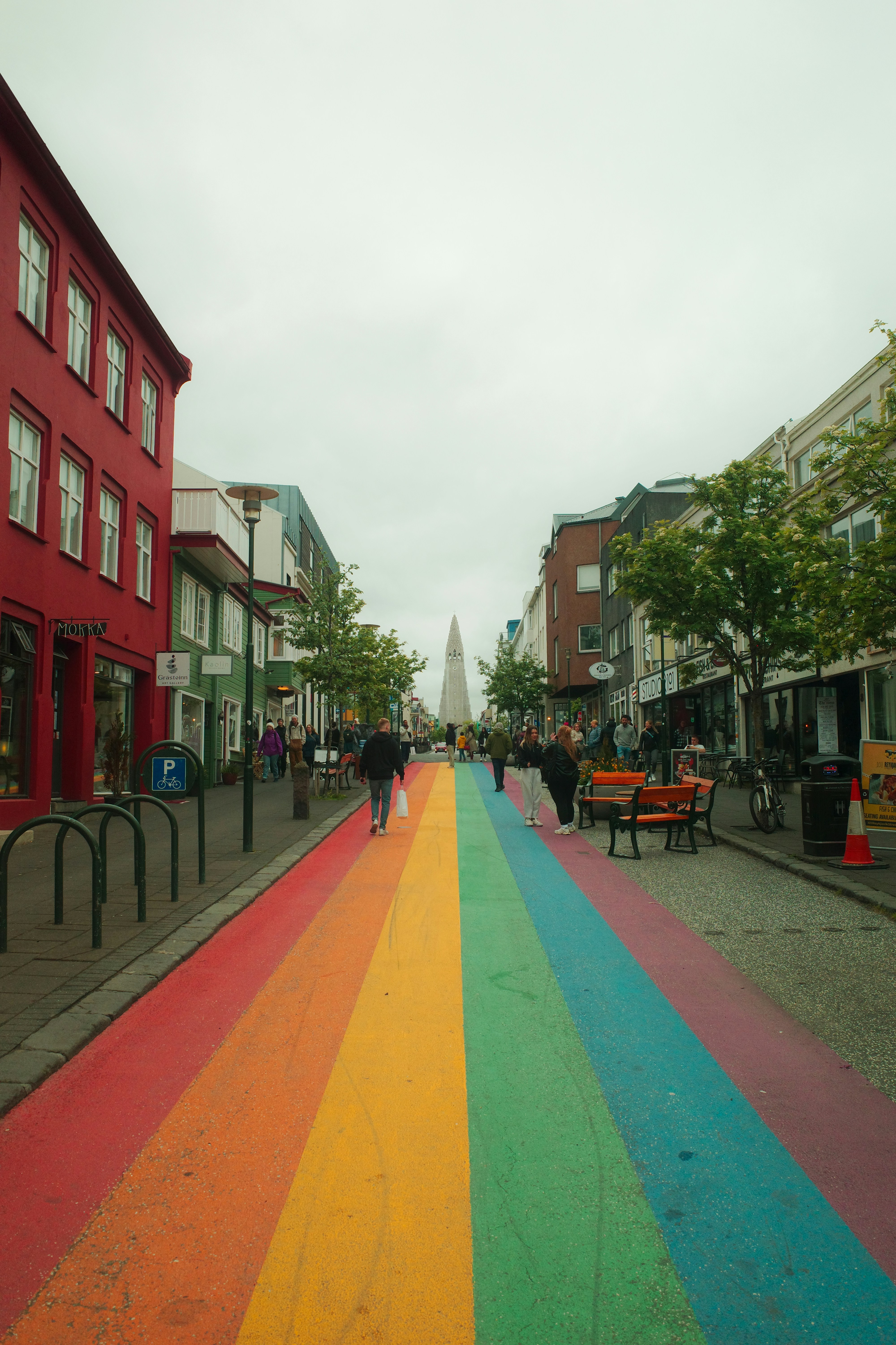 Rainbow Street in Focus: A Pedestrian Crossing the Colorful Avenue