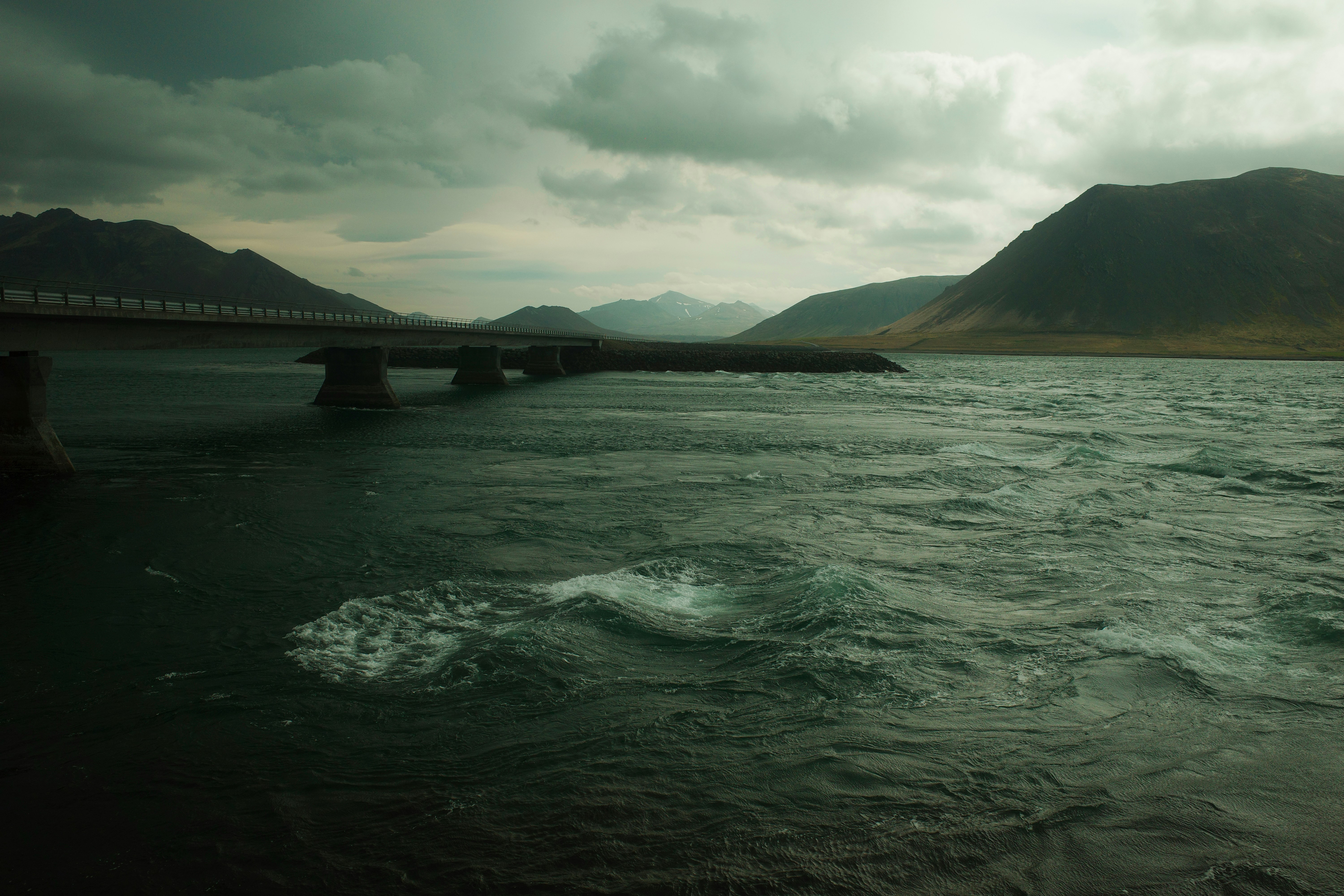 Bridge over the Quiet Fjord under Stormy Sky