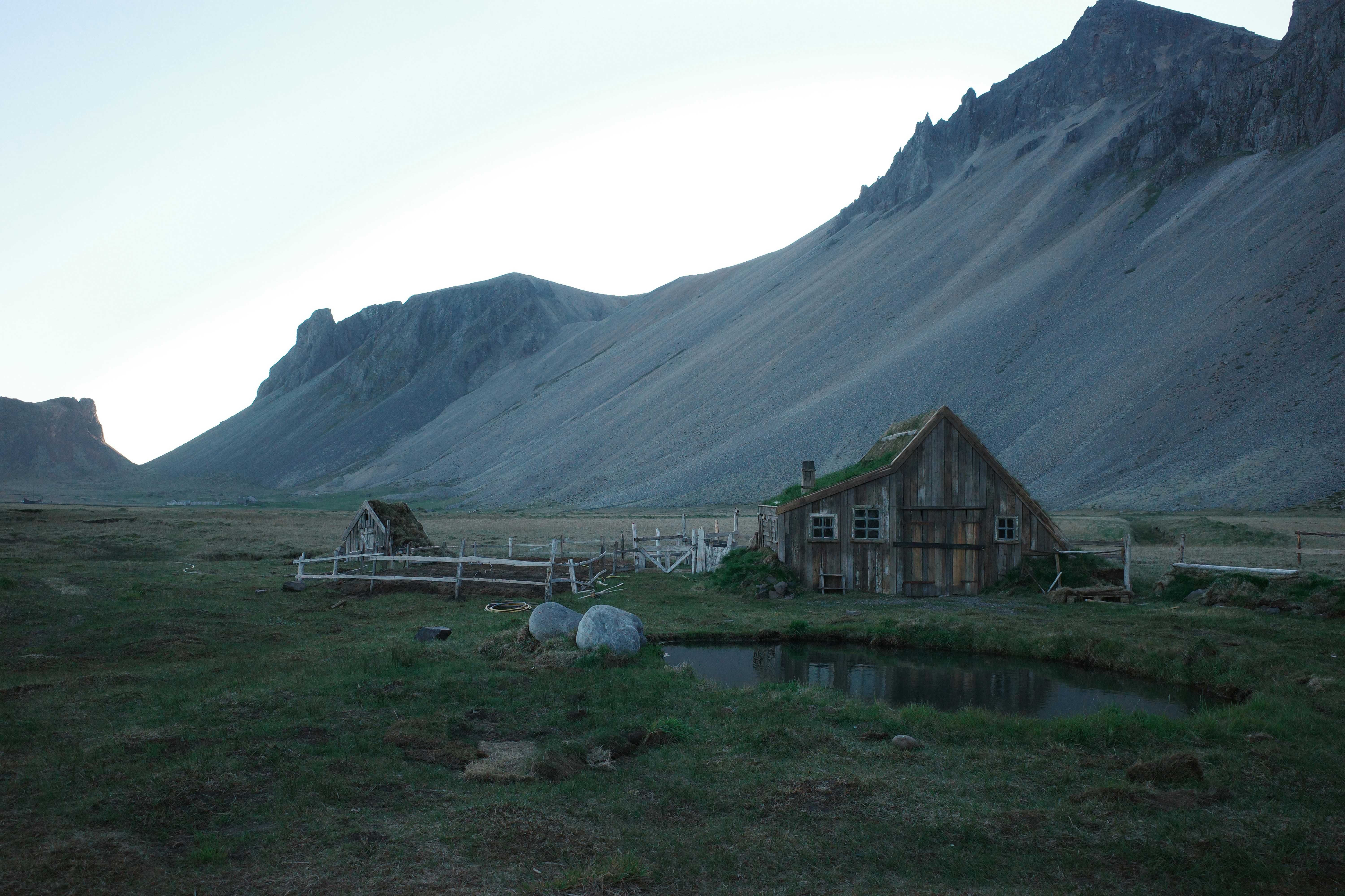 Weathered Cabin at the Foot of a Looming Ridge